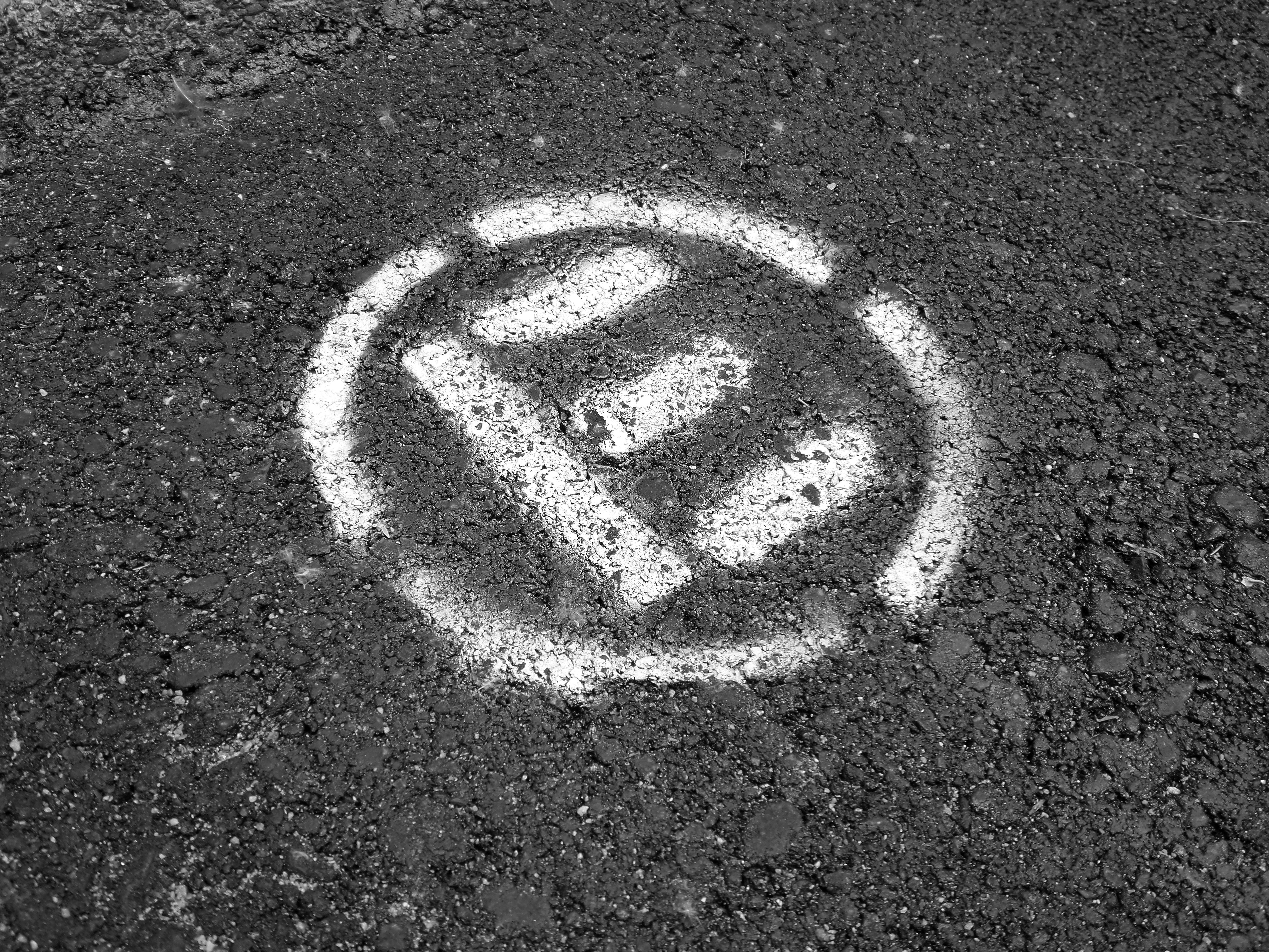 Emblem in the Cracks: A Circular Stencil on Asphalt