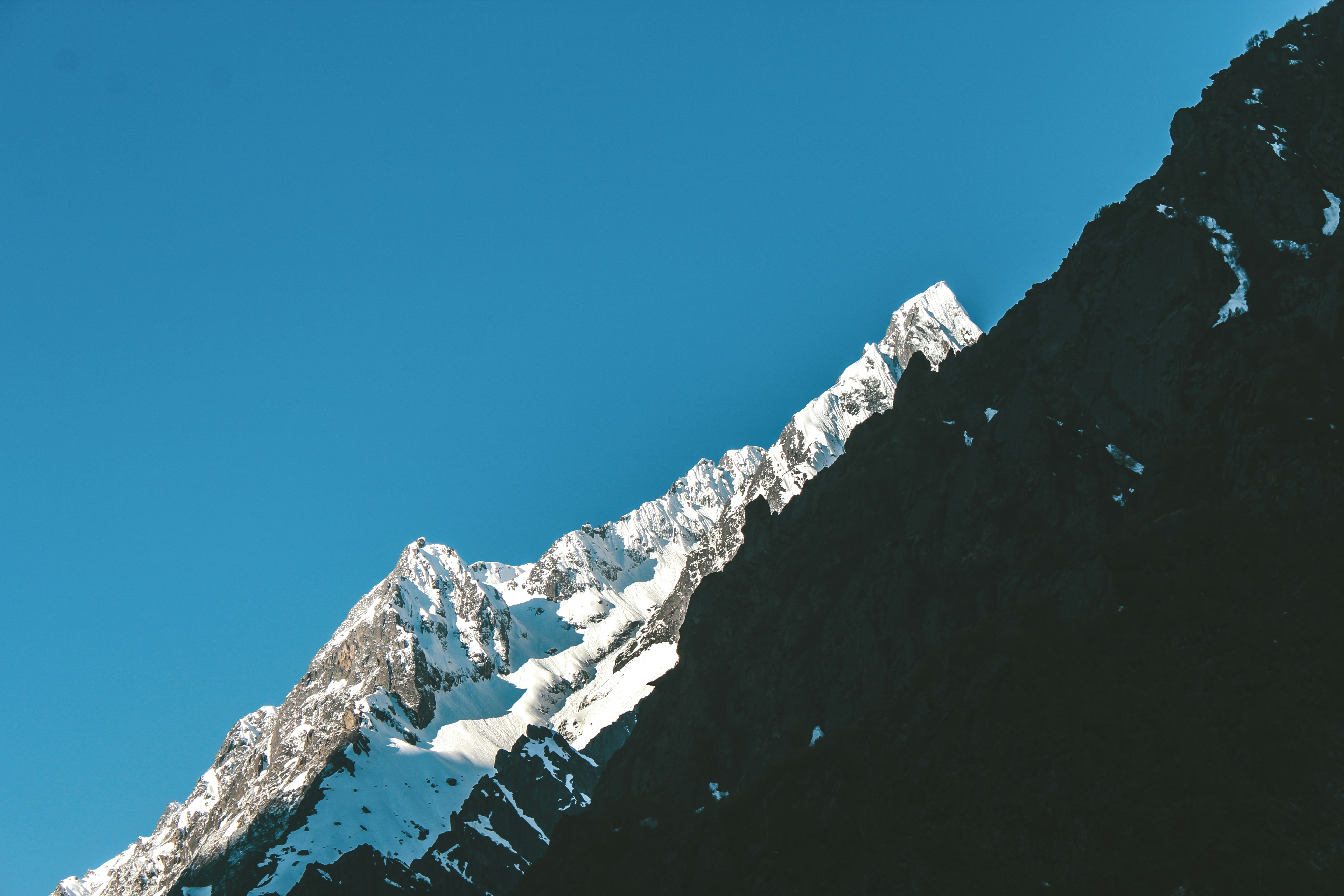 Snow-White Spur Against Azure Sky: A Mountain Ridge Portrait
