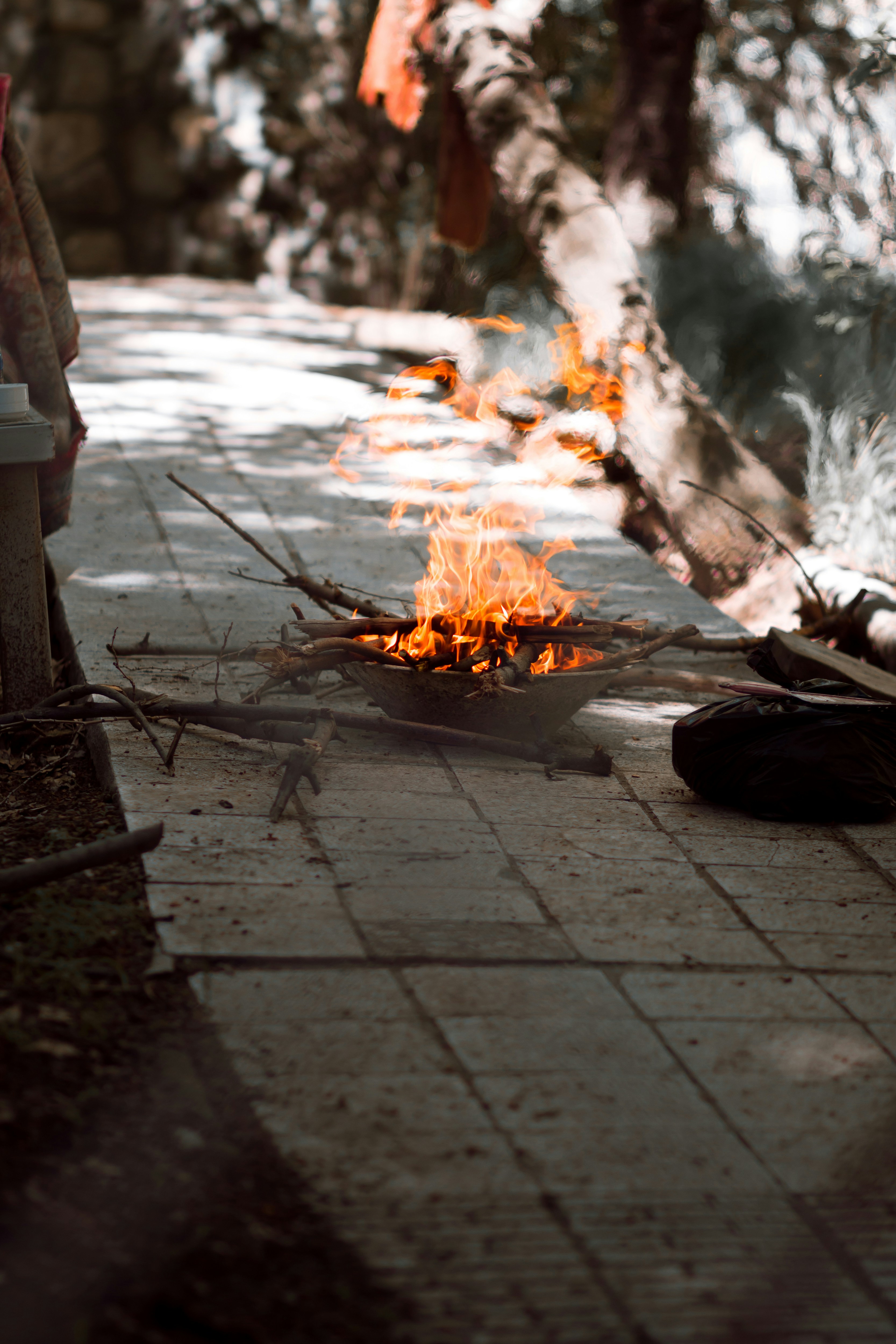 Candlelit ritual on a stone path with a central brazier of fire