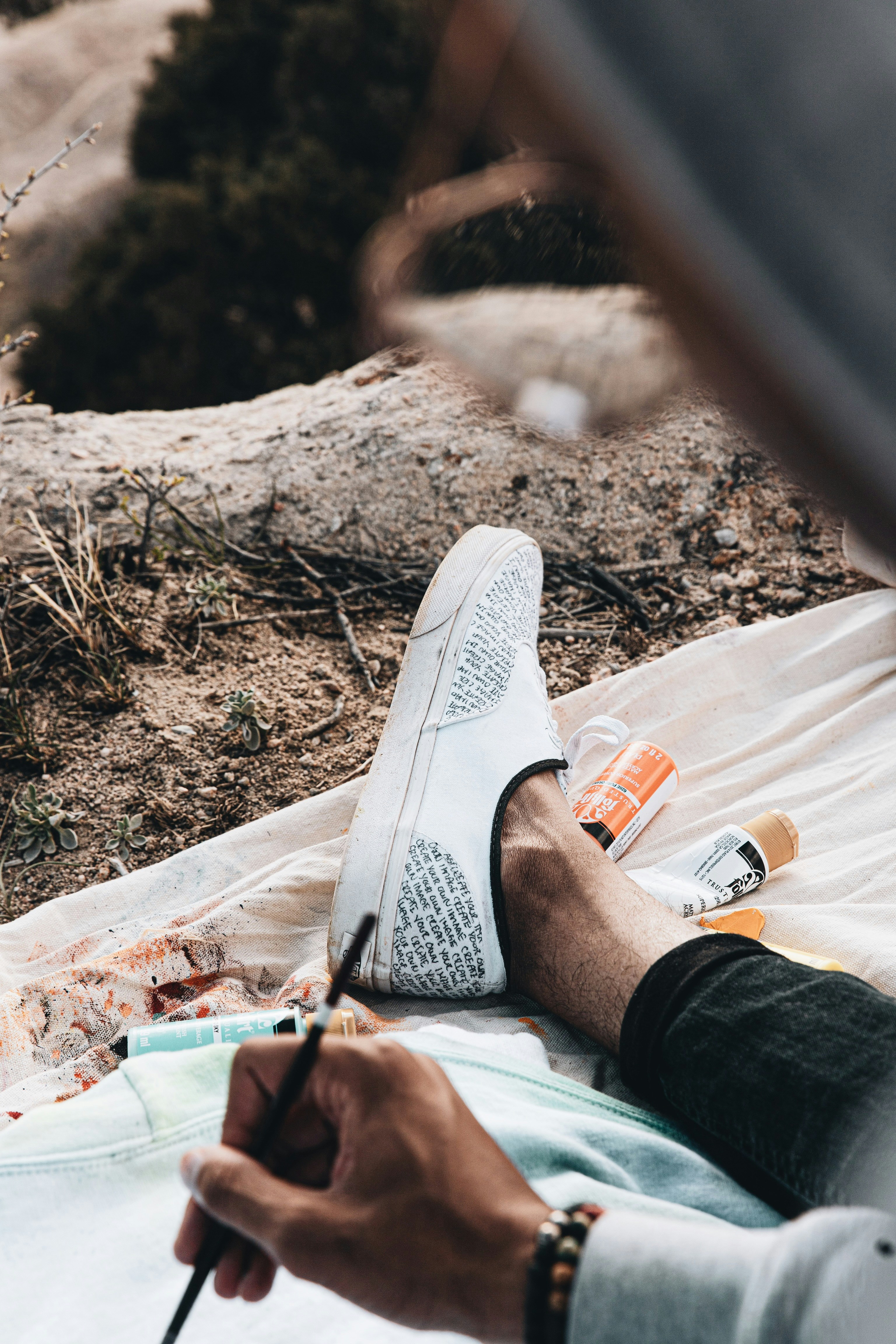 White sneaker in focus: a painterly moment mid-studio on a sunlit blanket