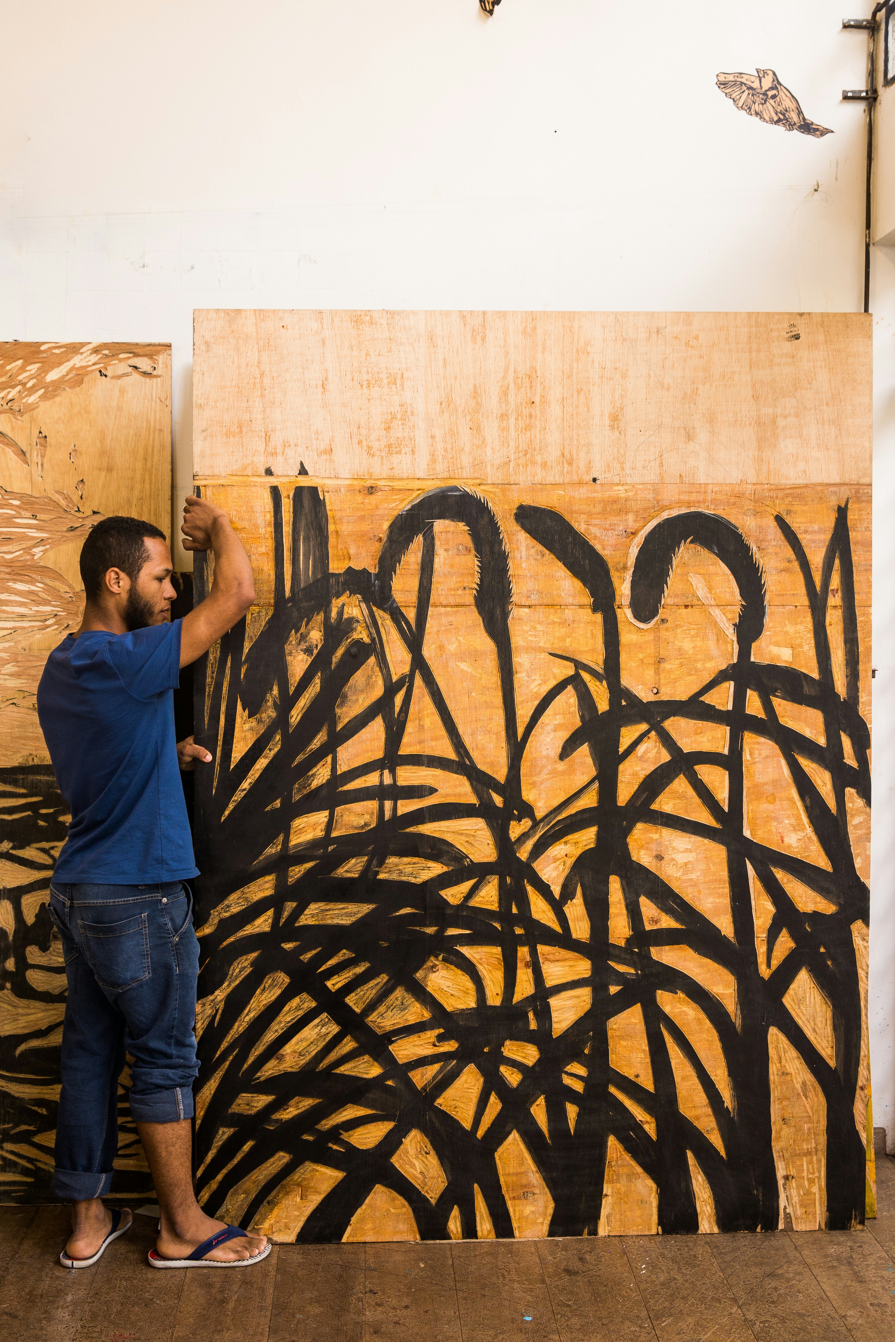 Blue-Clad Figure Beside a Graffiti-Covered Plywood Wall