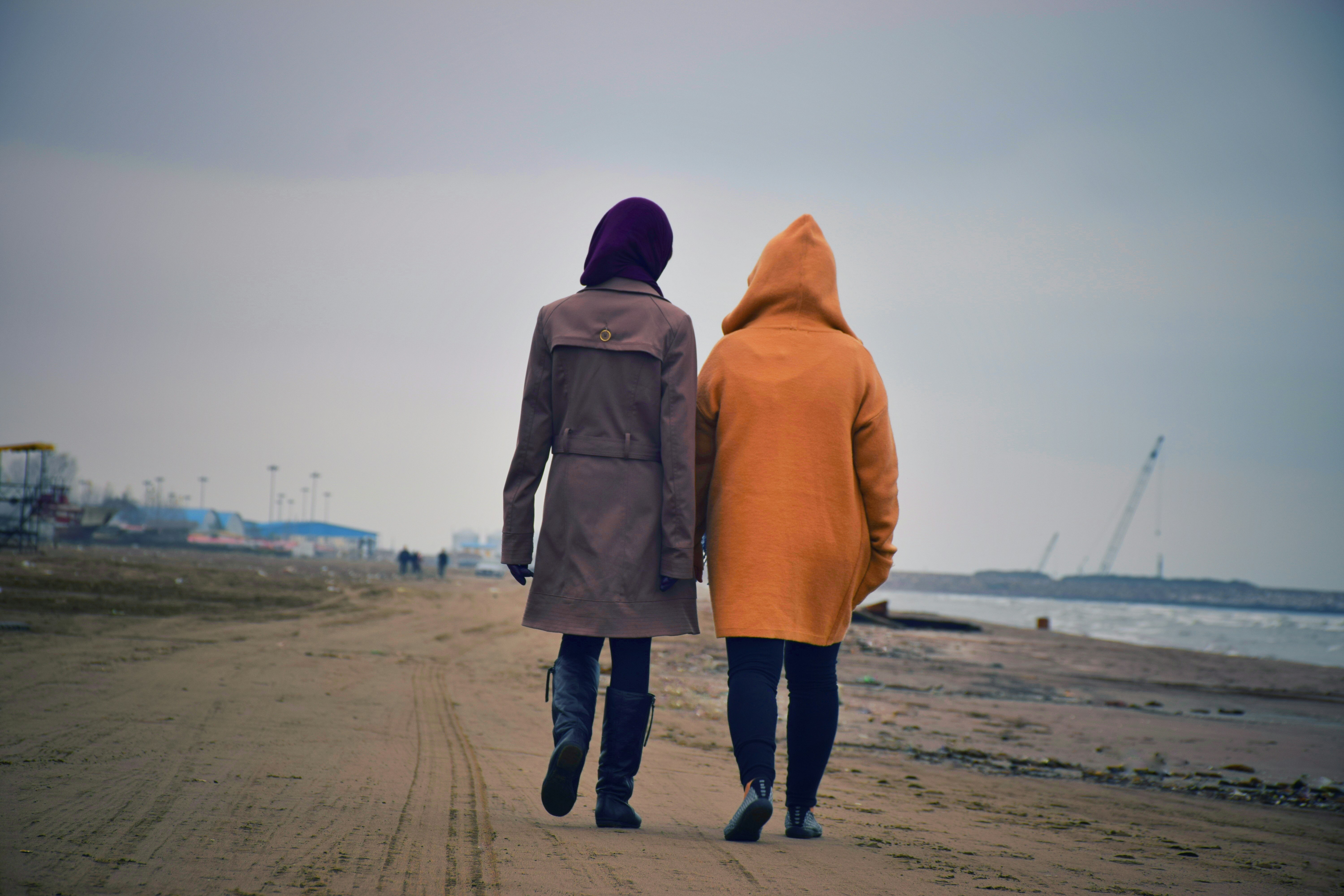 Two in Warm Coats on a Quiet Seaside Walk