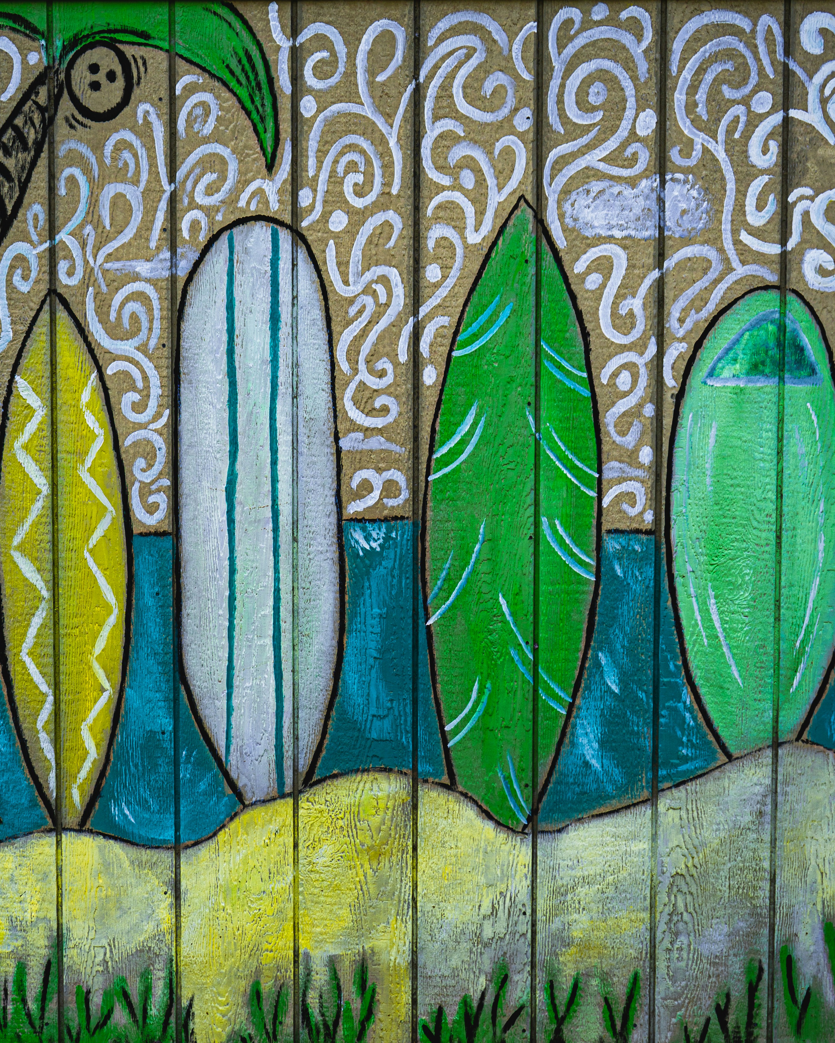 Surfboard Leaves on a Wooden Shore: A Colorful Fence Fresco