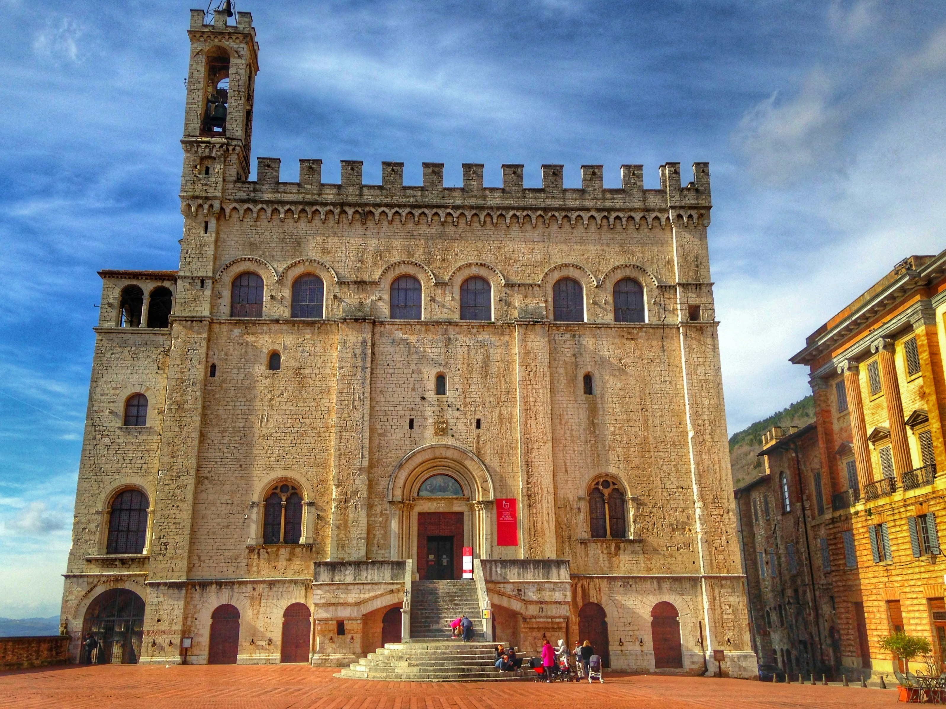 Historic stone building with crenellated tower under a vivid blue sky.