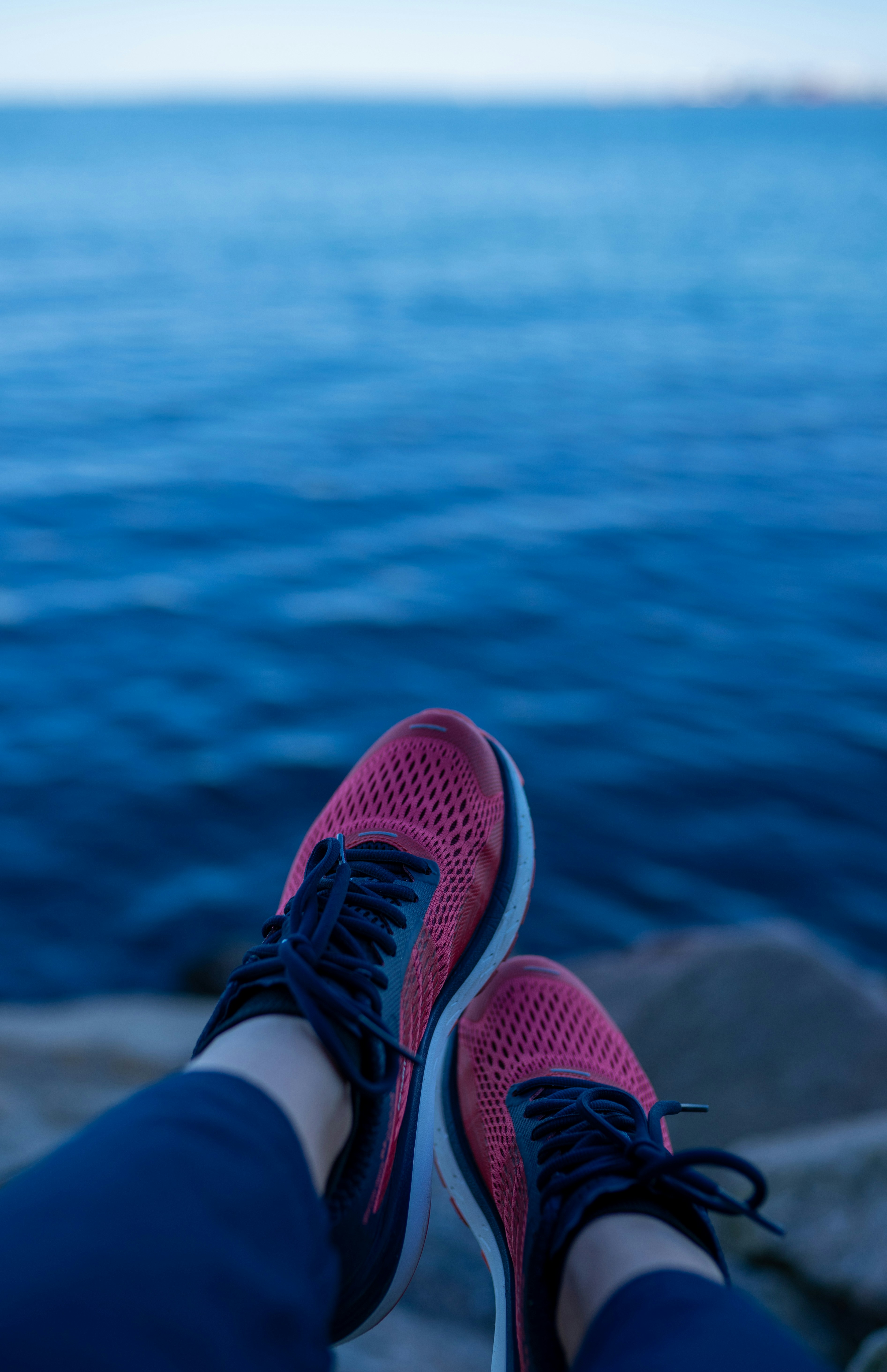 Footwear on the Edge: Neon Pink Sneakers Meet the Sea