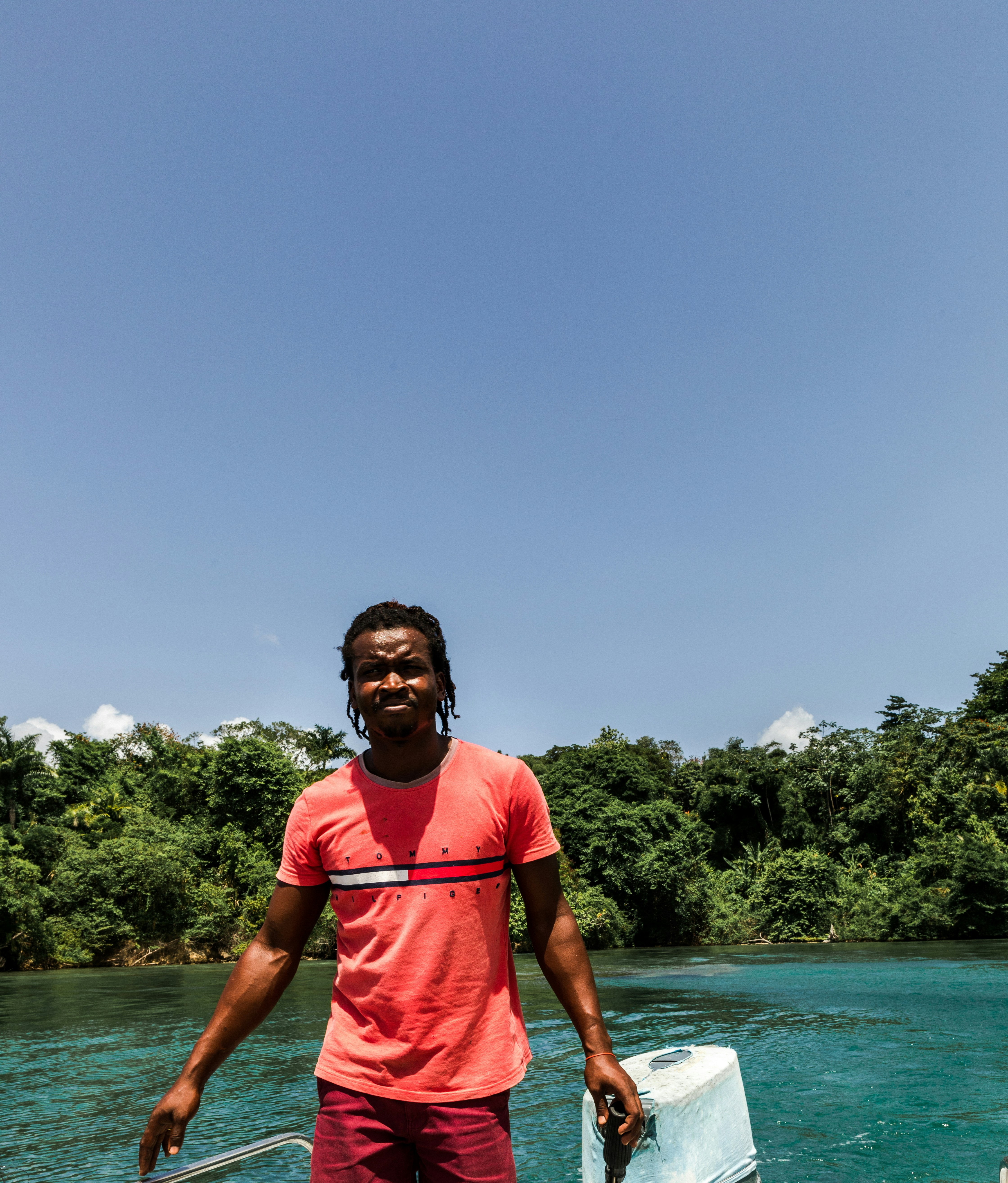 Bowside Resolve: Portrait at the Bow Amid Turquoise Waters and Lush Shoreline