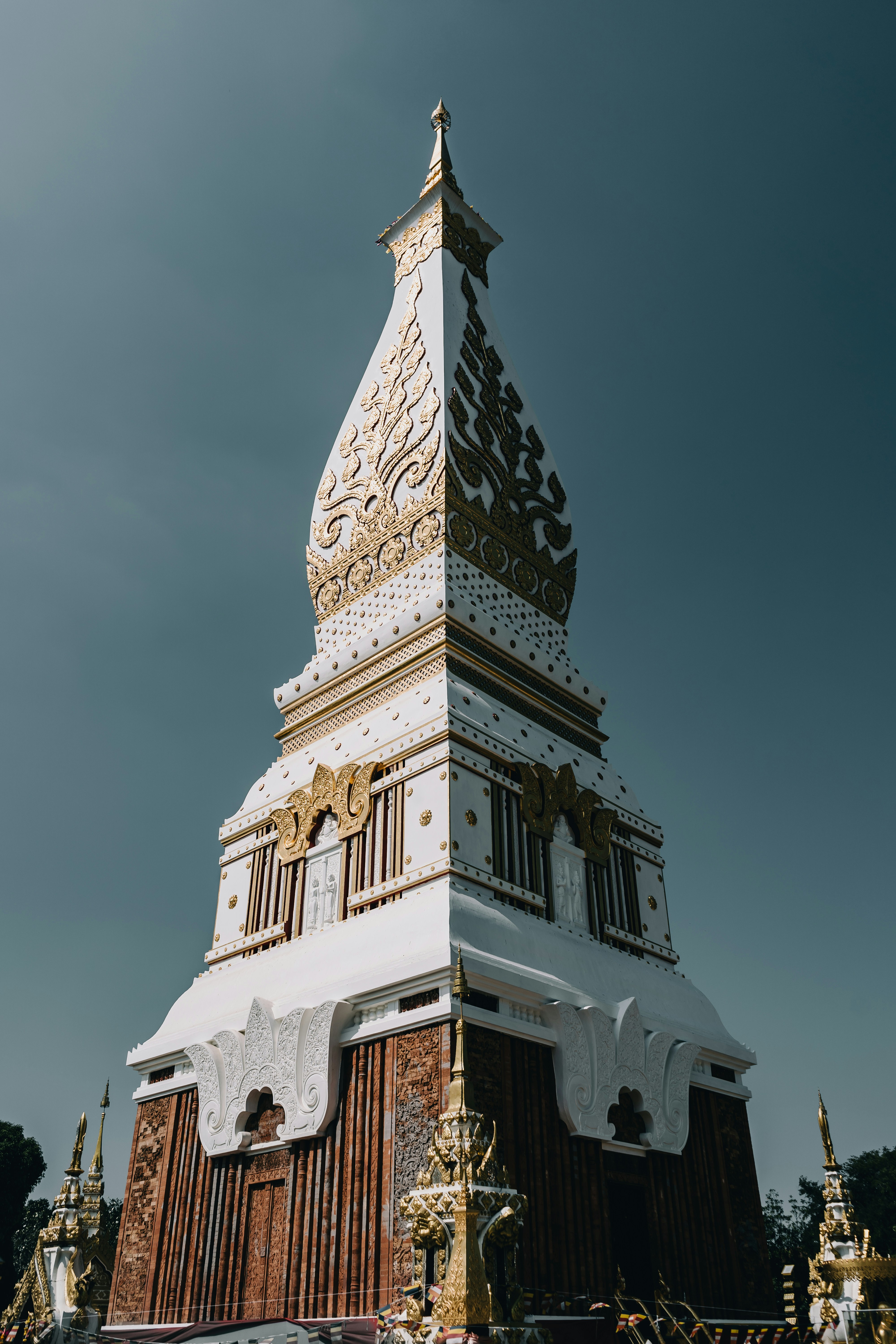 Ornate white and gold temple tower reaching into a clear blue sky.