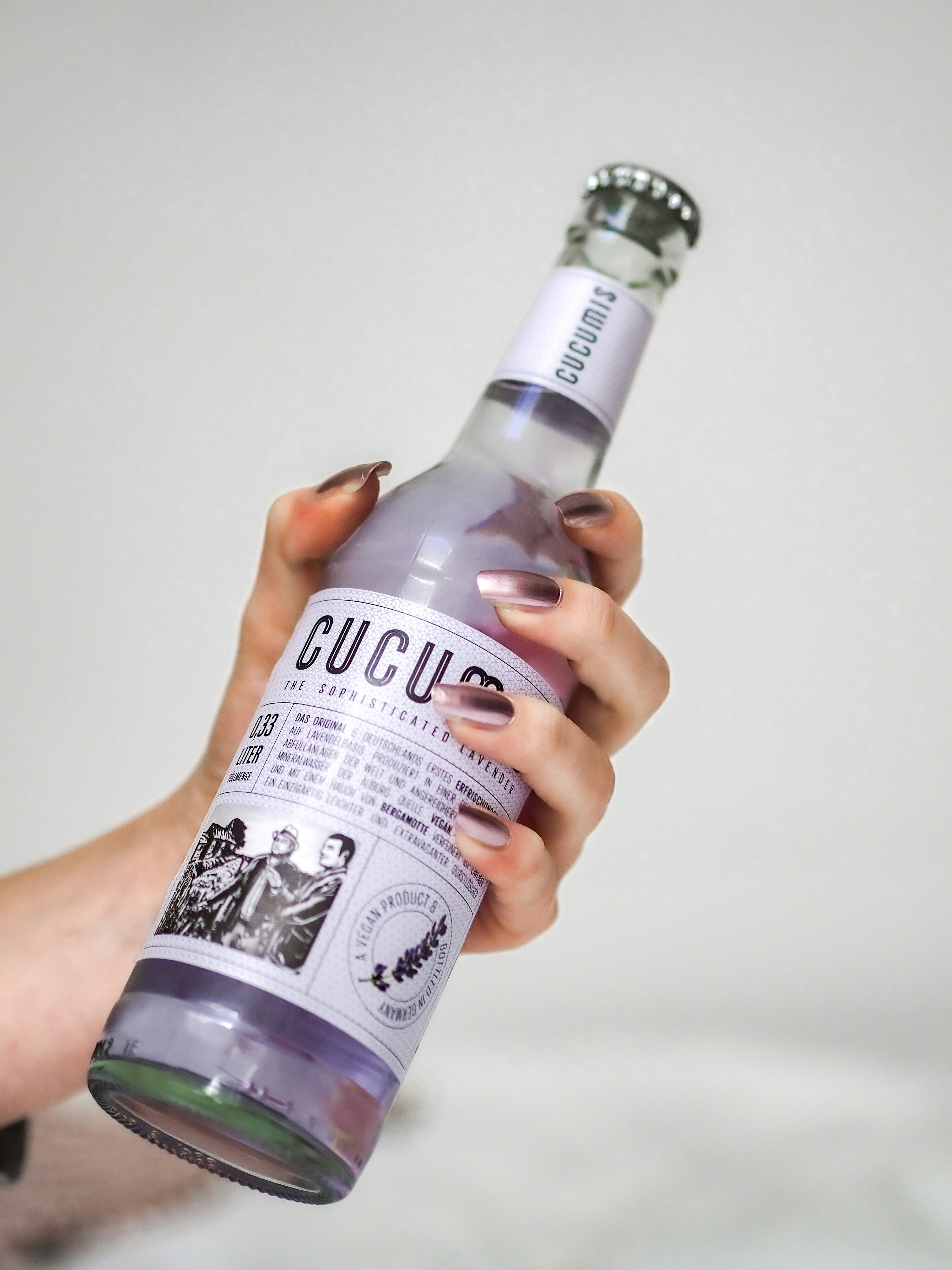 person holding clear glass bottle