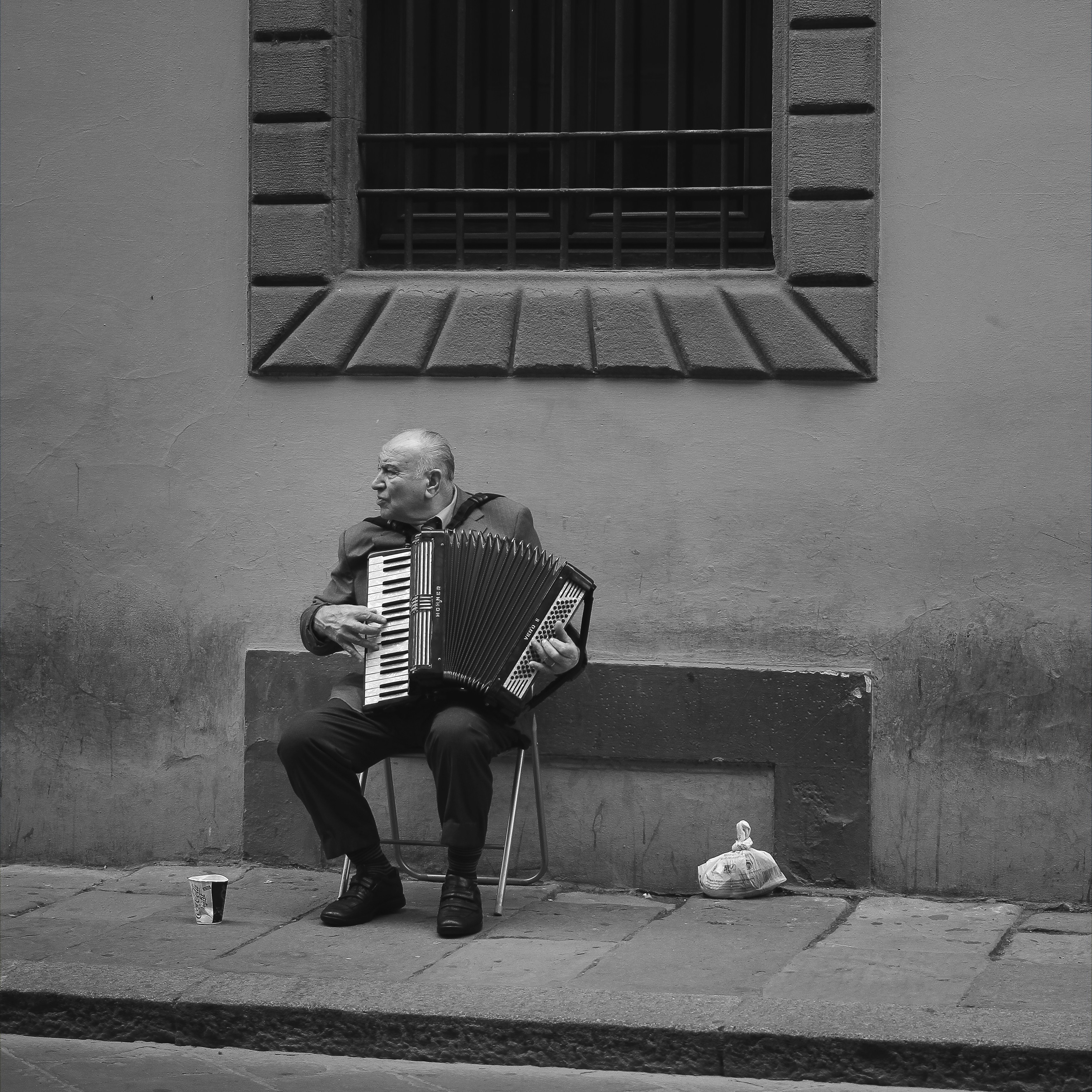 Man playing musical instrument on street in grayscale photography photo ...