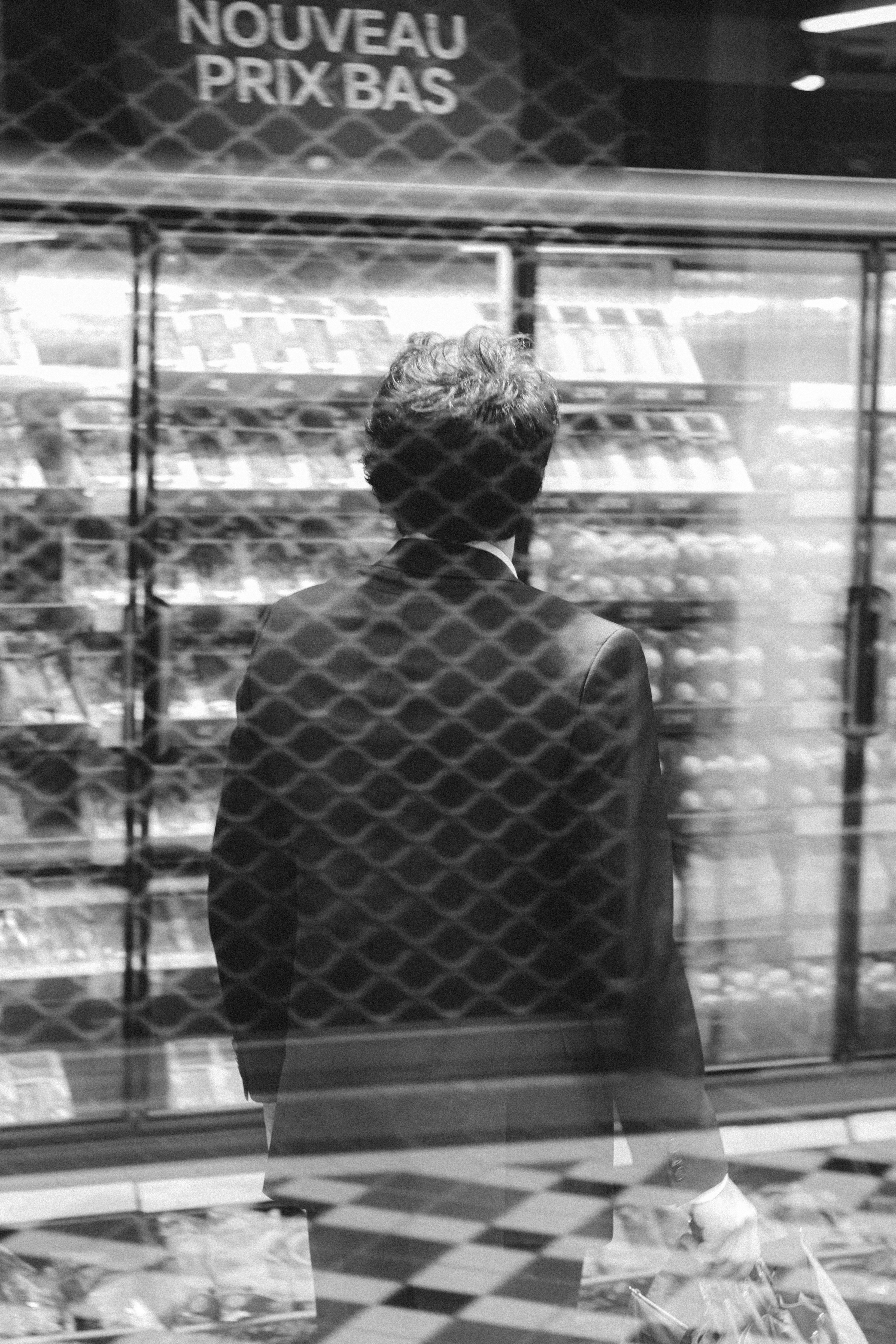 grayscale photo of person in front of window