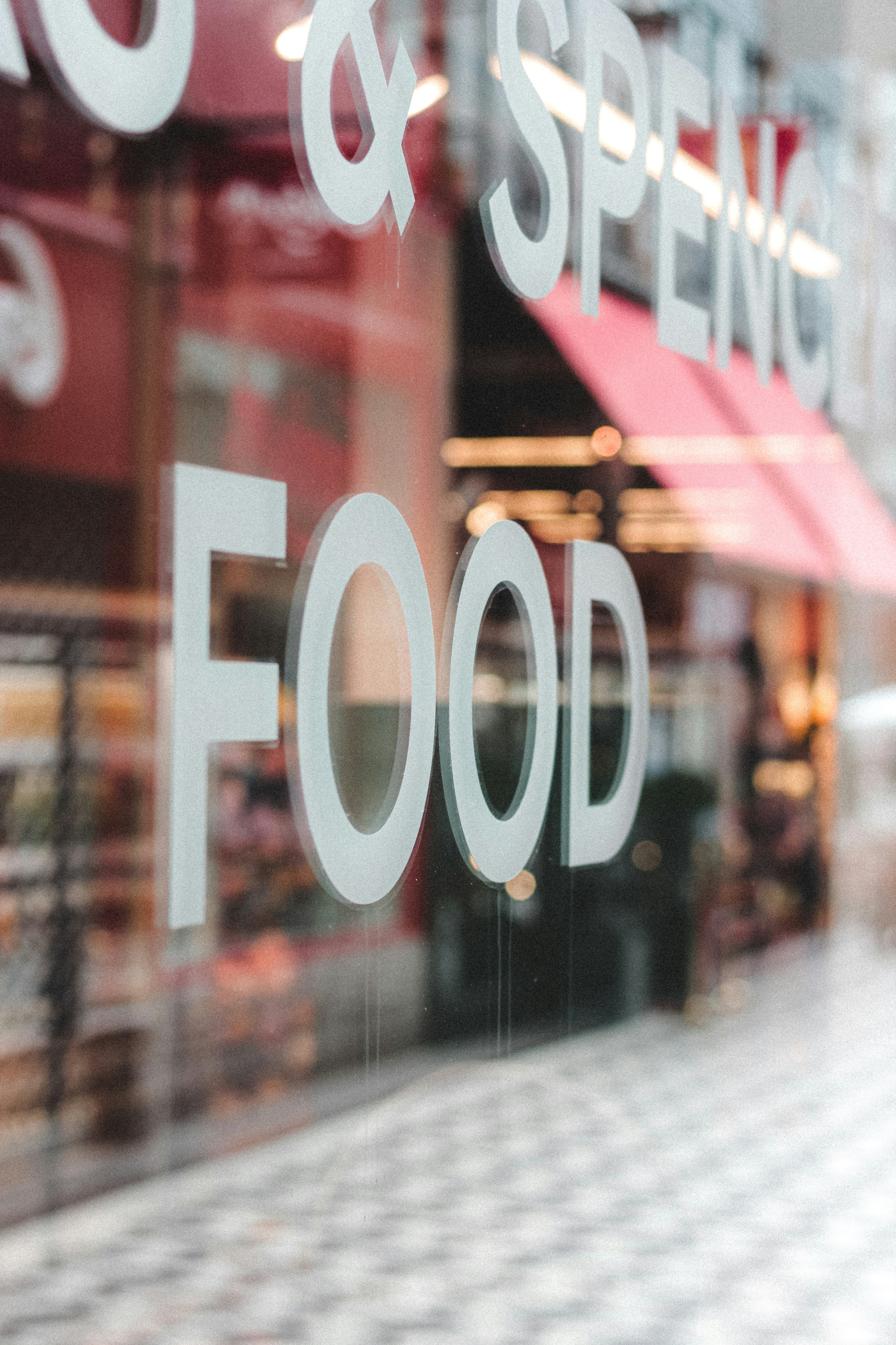 Through the Glass: Bold 'FOOD' Sign Framed by Warm City Reflections
