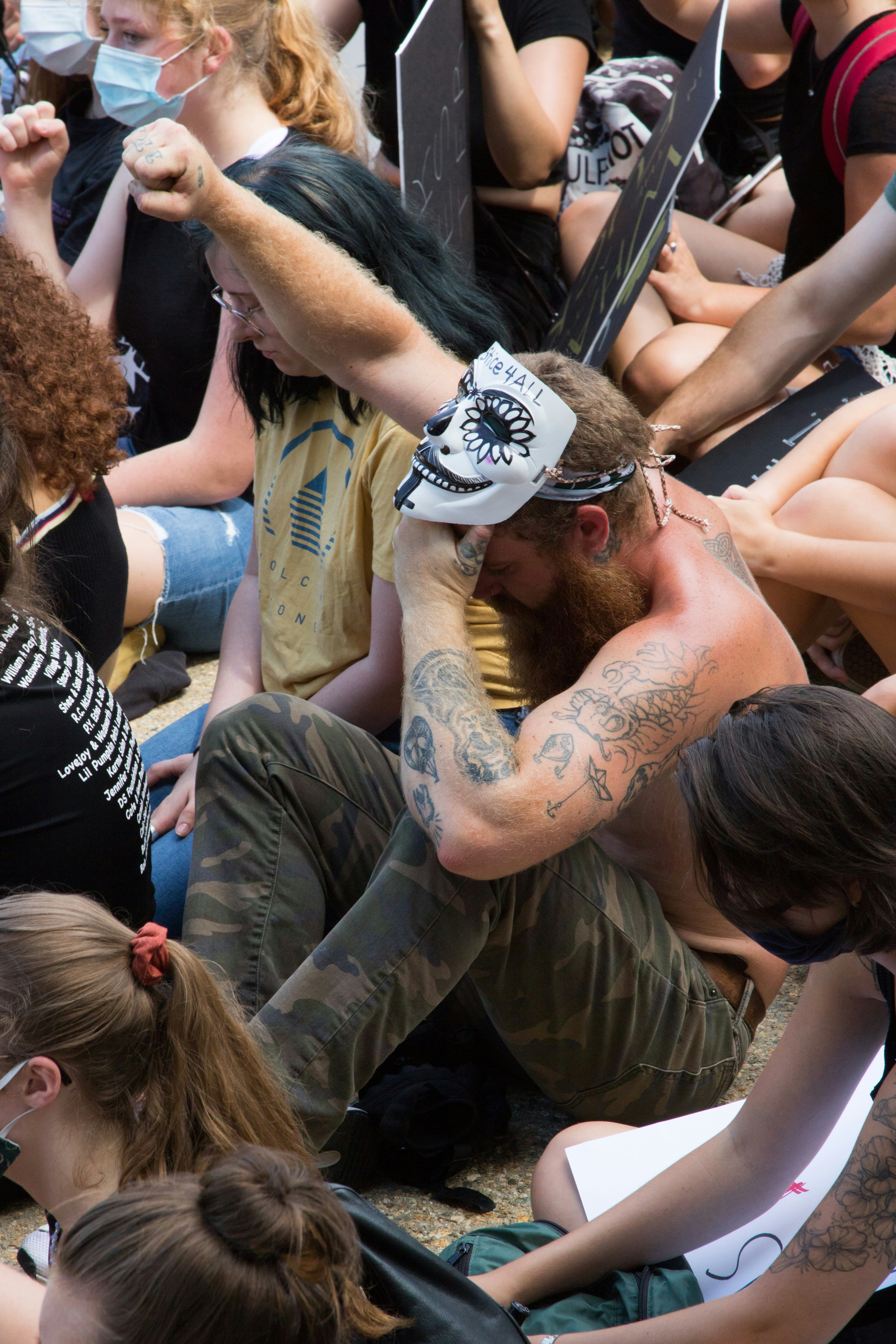 Bandana-clad protester rests among a crowded sea of faces