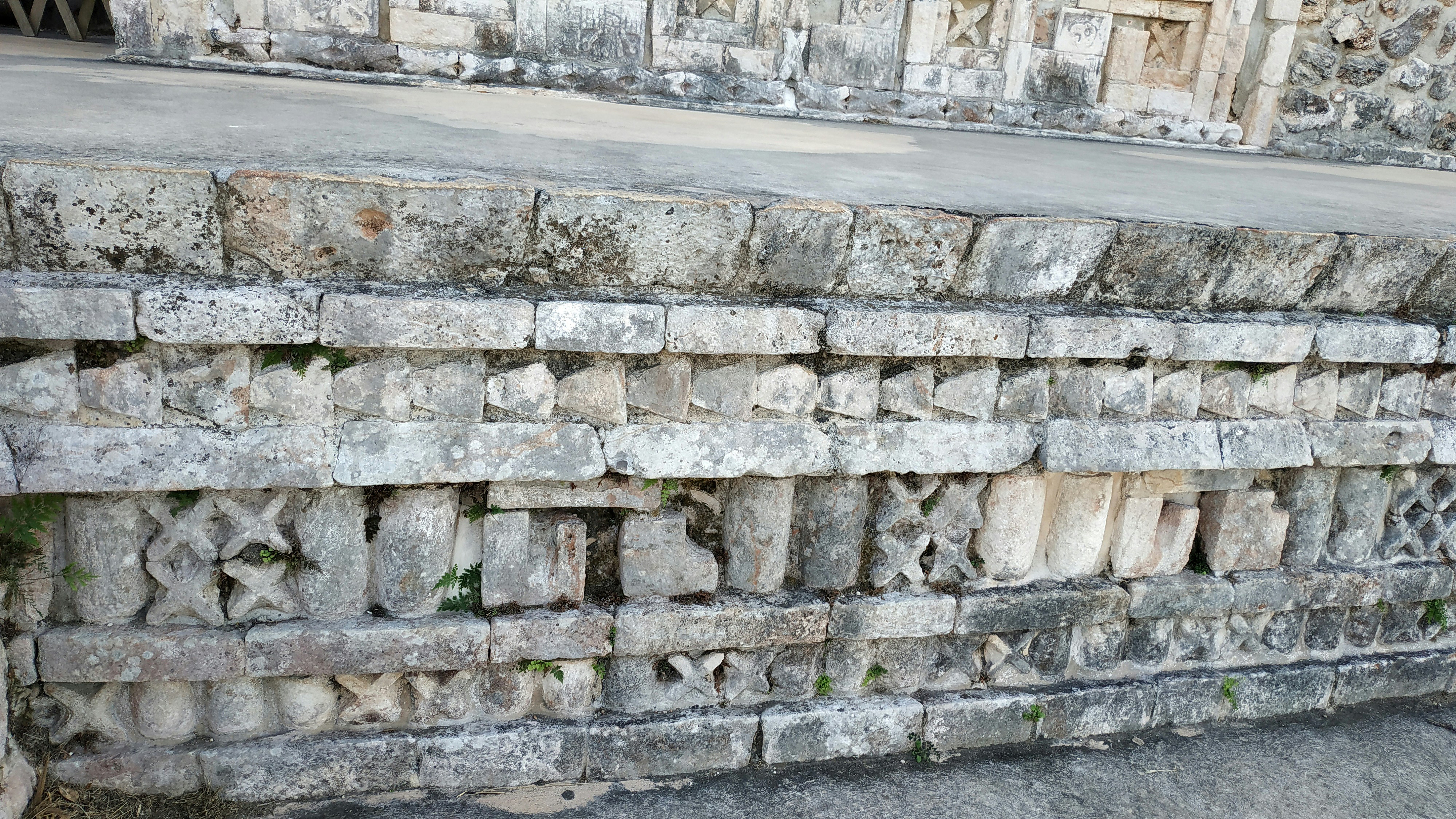 Ornate carvings on ancient Mayan ruins showcasing geometric and floral motifs.
