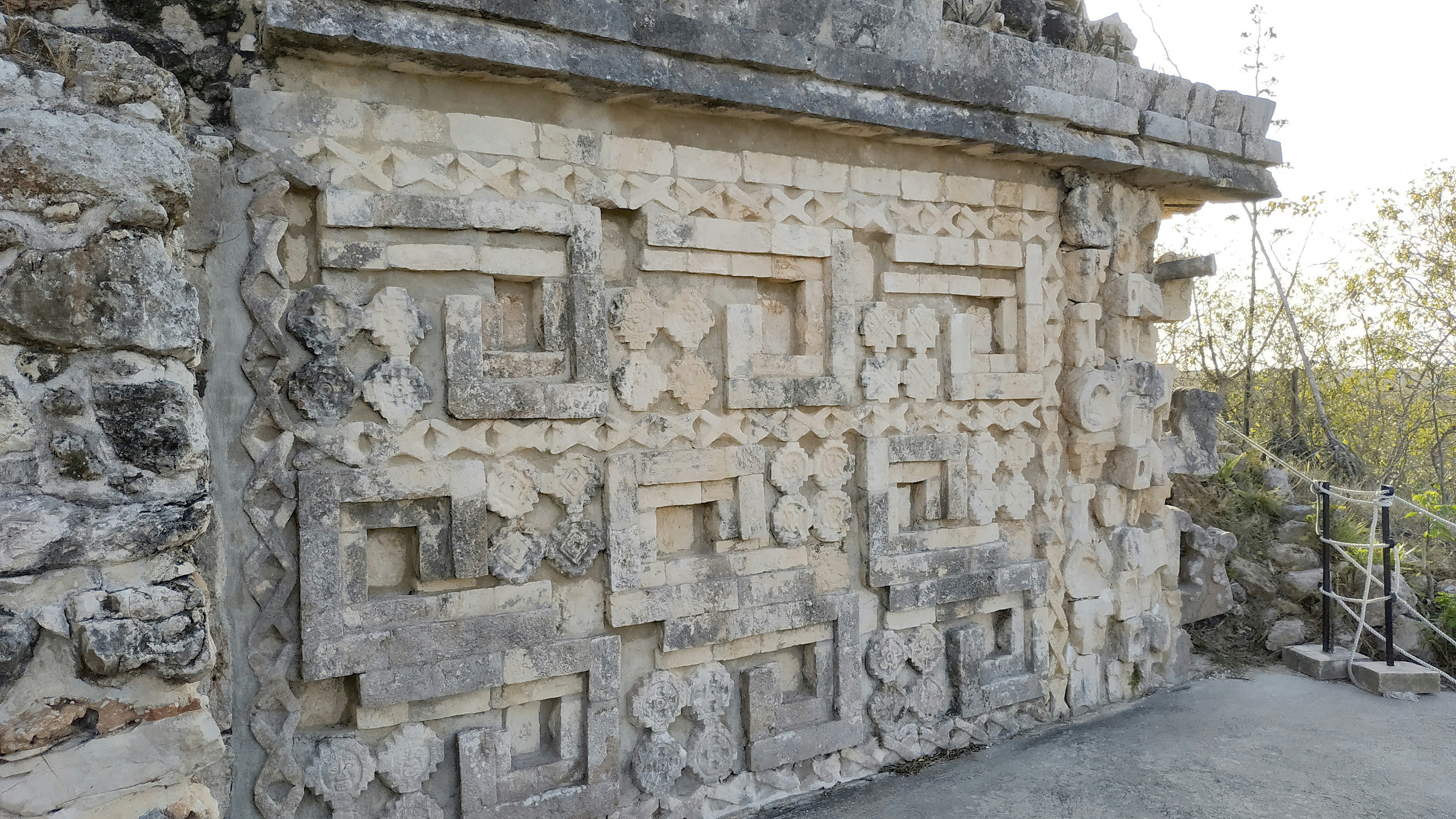 Detailed stone carvings on ancient Mayan ruins showcase geometric patterns at Uxmal.