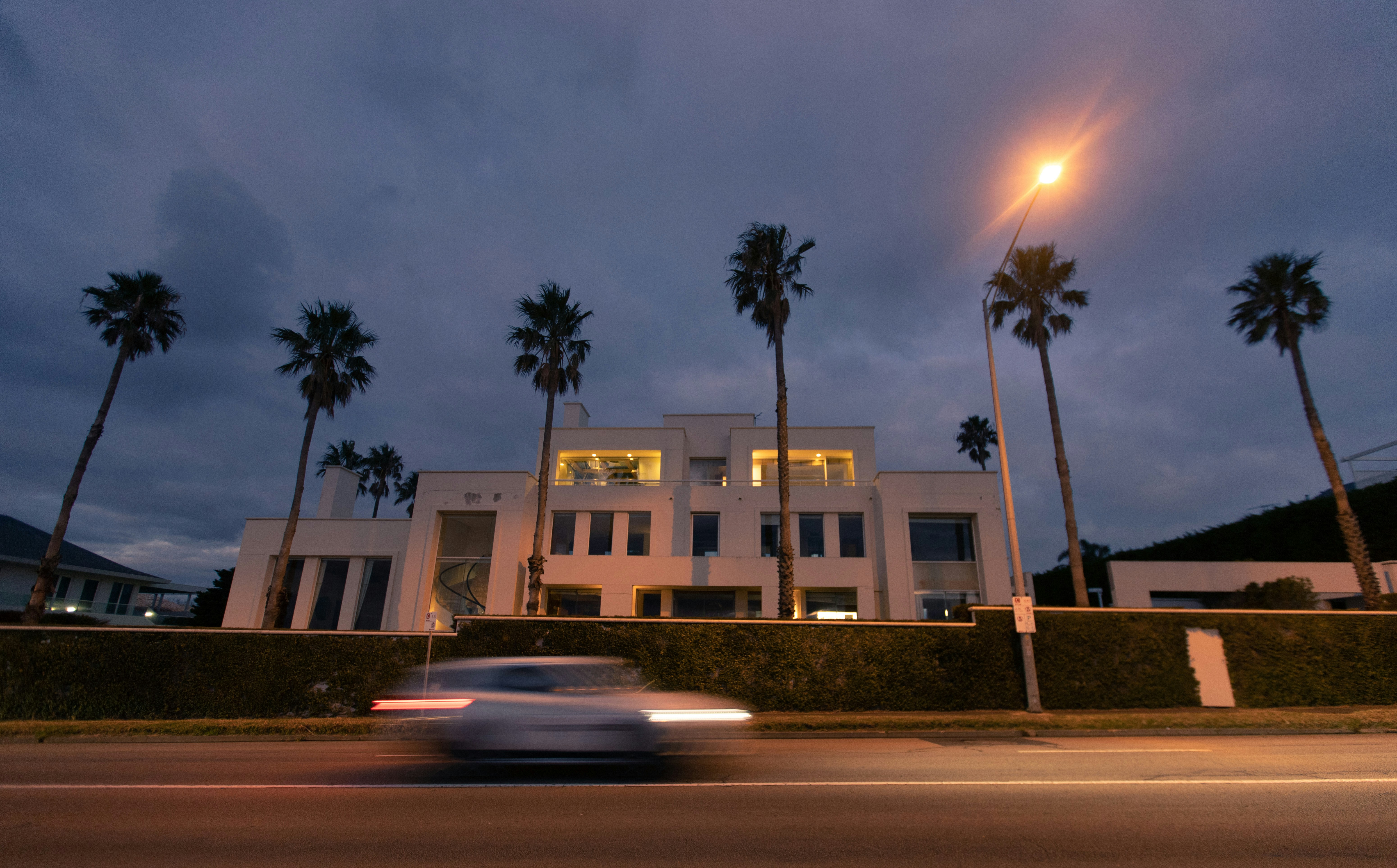 Neon-lit residence beneath a moody dusk sky