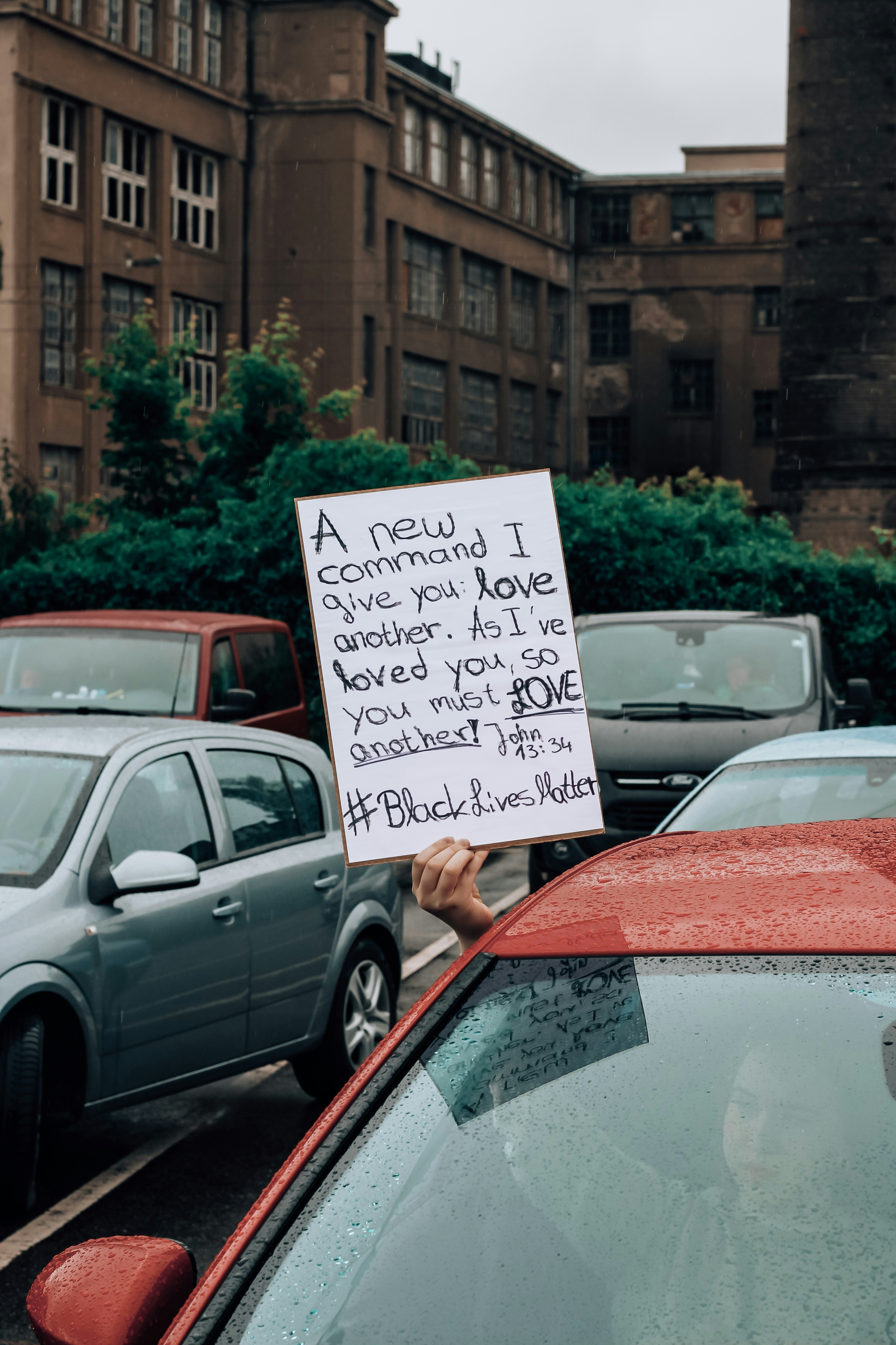 person holding white printer paper near cars during daytime