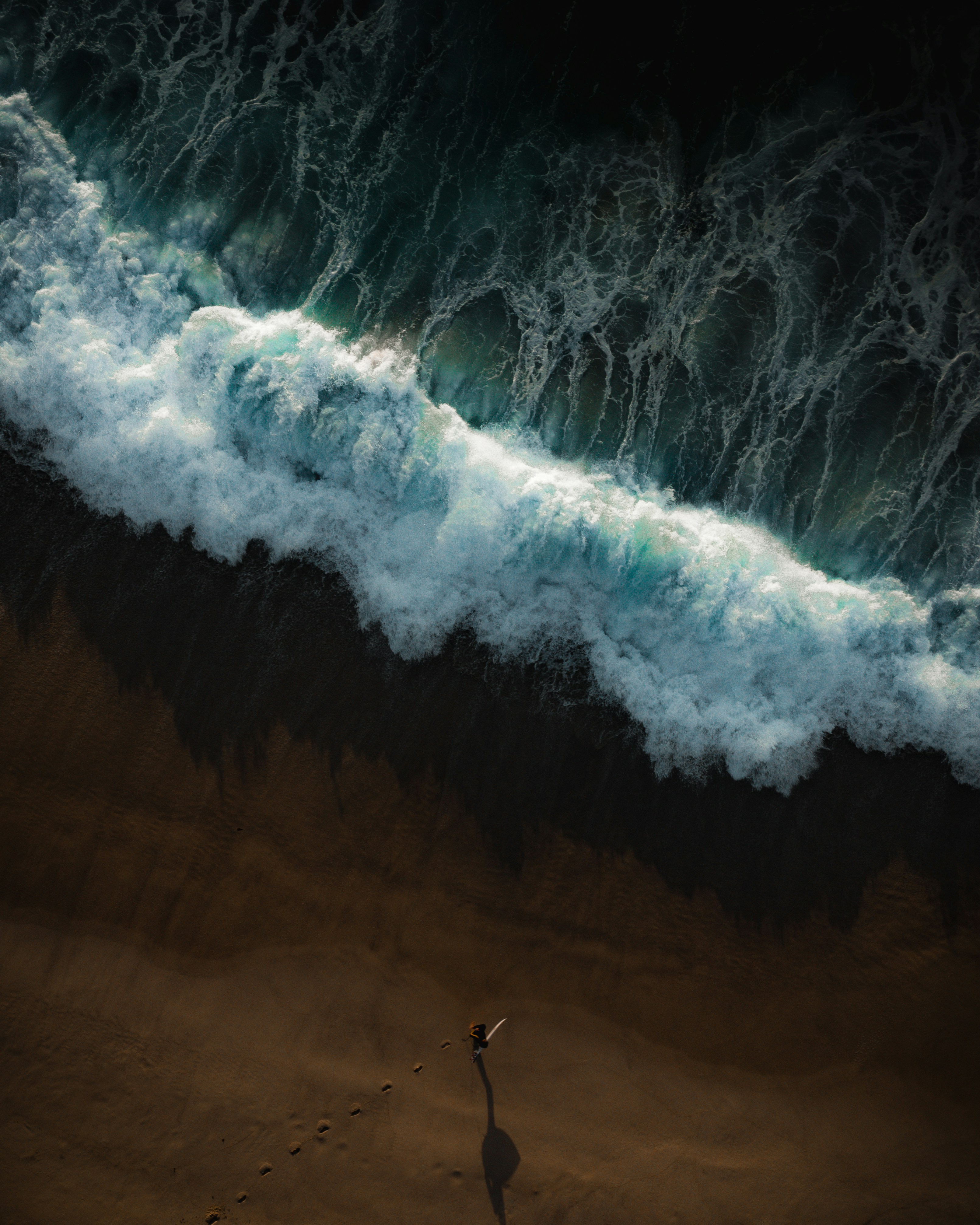 Diagonal Shoreline: A Solitary Figure Traverses the Wave-Swept Beach