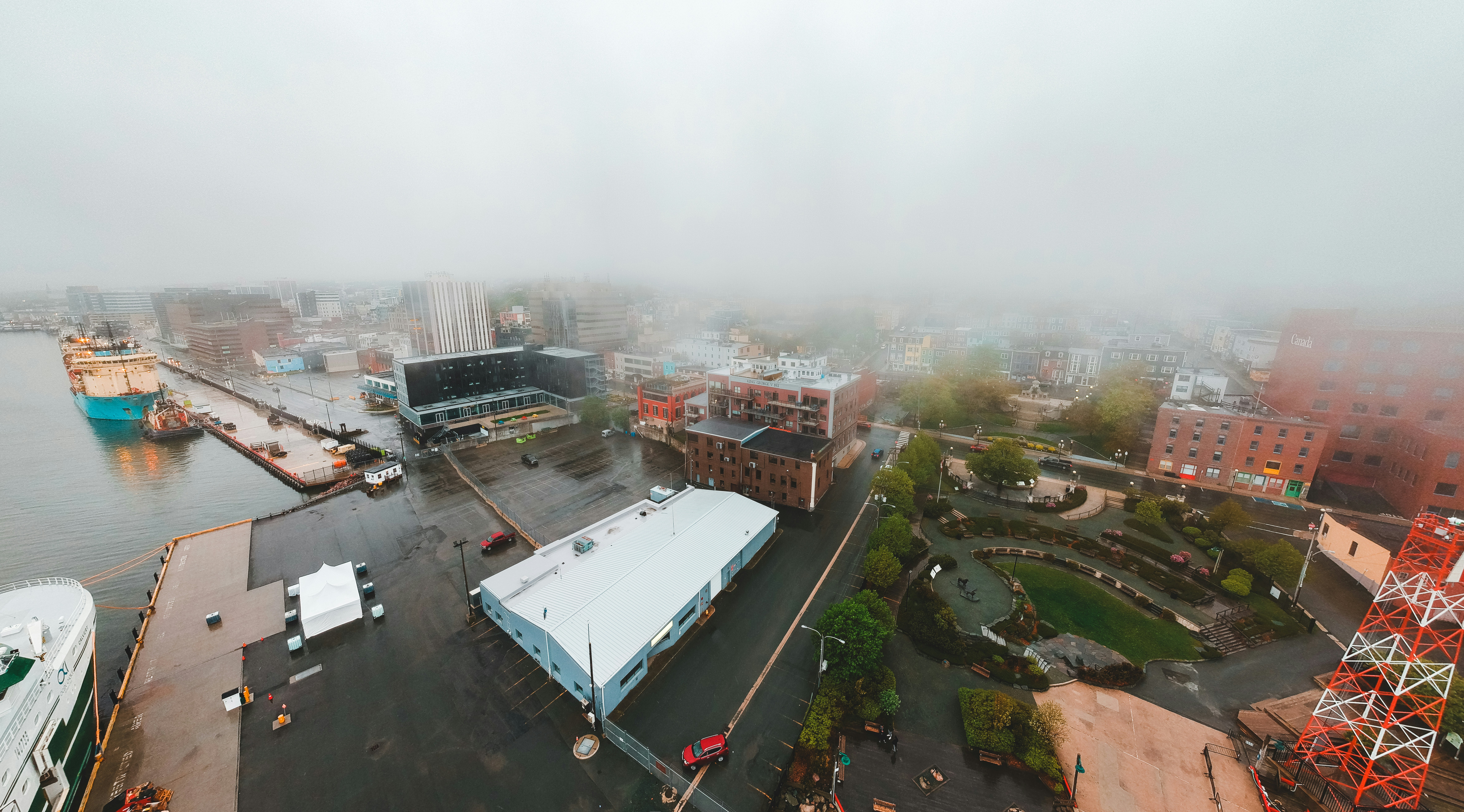 Fogbound Waterfront: A Drone's Eye over Dockyards and Red-Brick Blocks