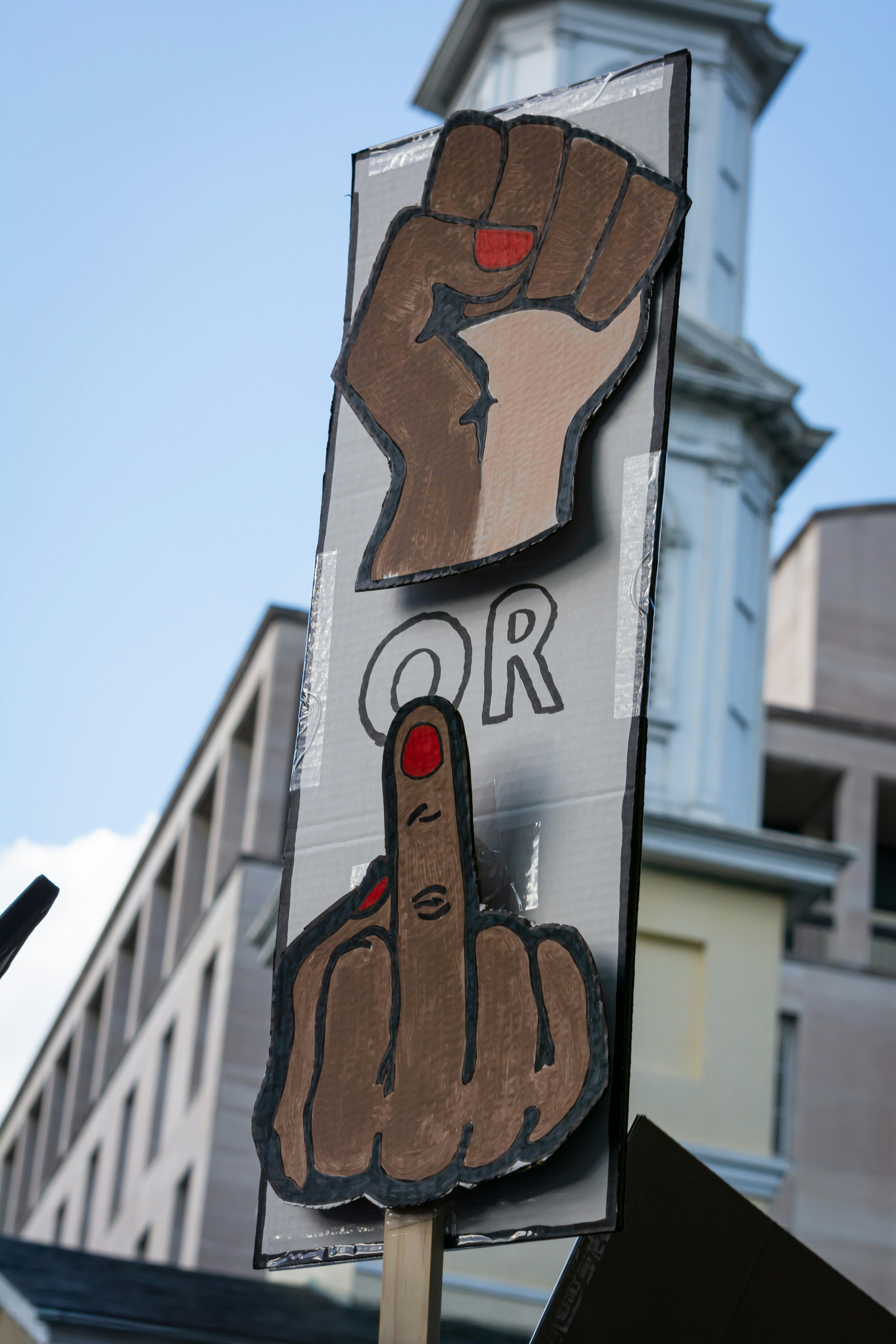 Banner of Defiance: Cartoon Hands Protest Sign Against the City Sky