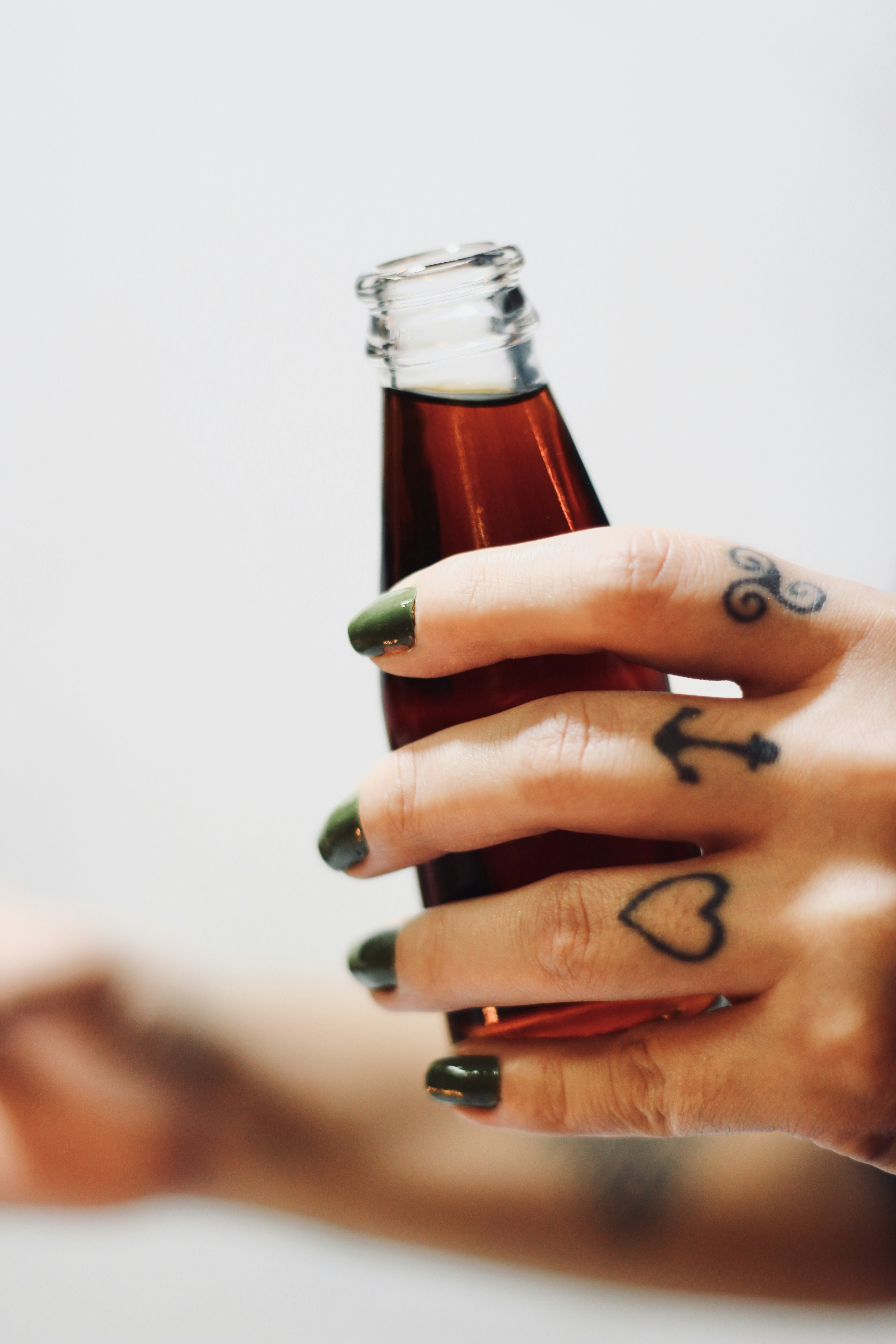Outline of a Handful of Night Shade: A Close-Up on a Tattooed Grip