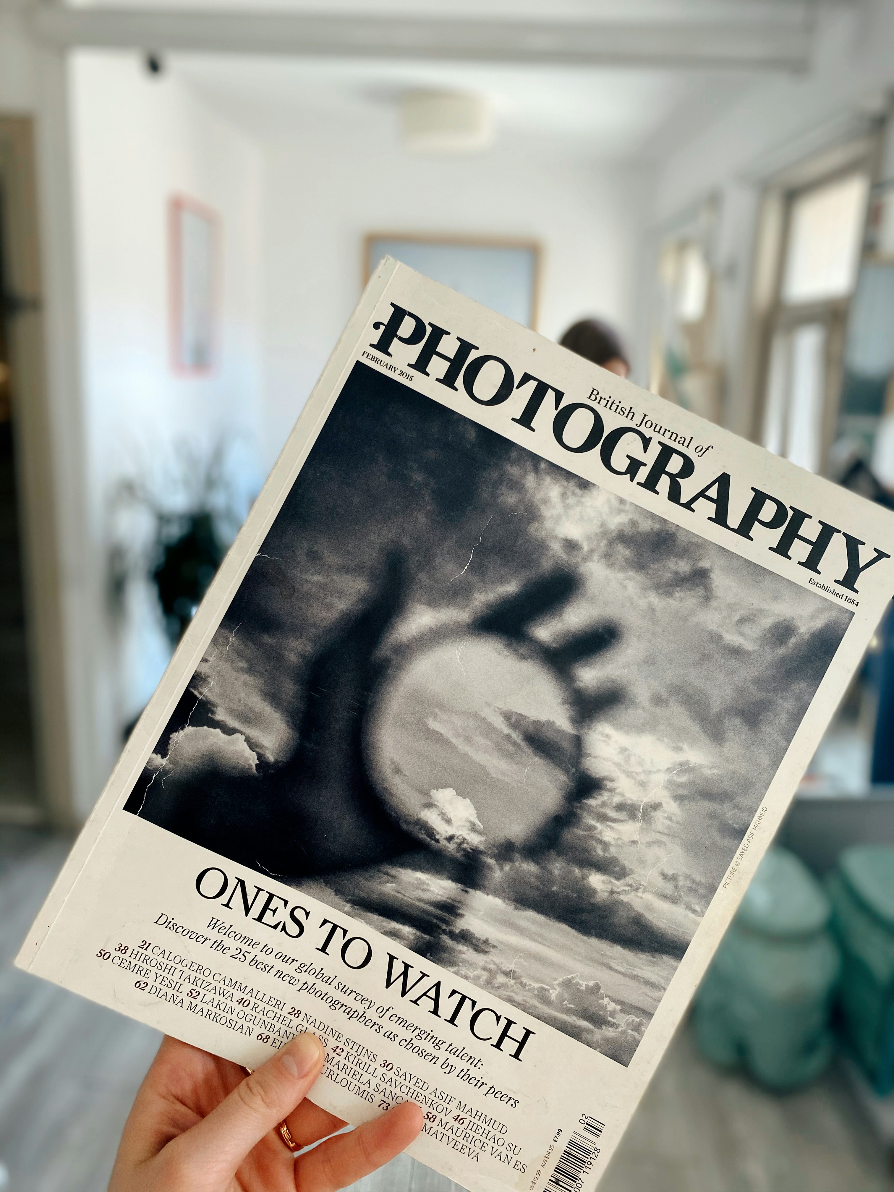 A person holding up a newspaper with a picture of a clock on it photo ...