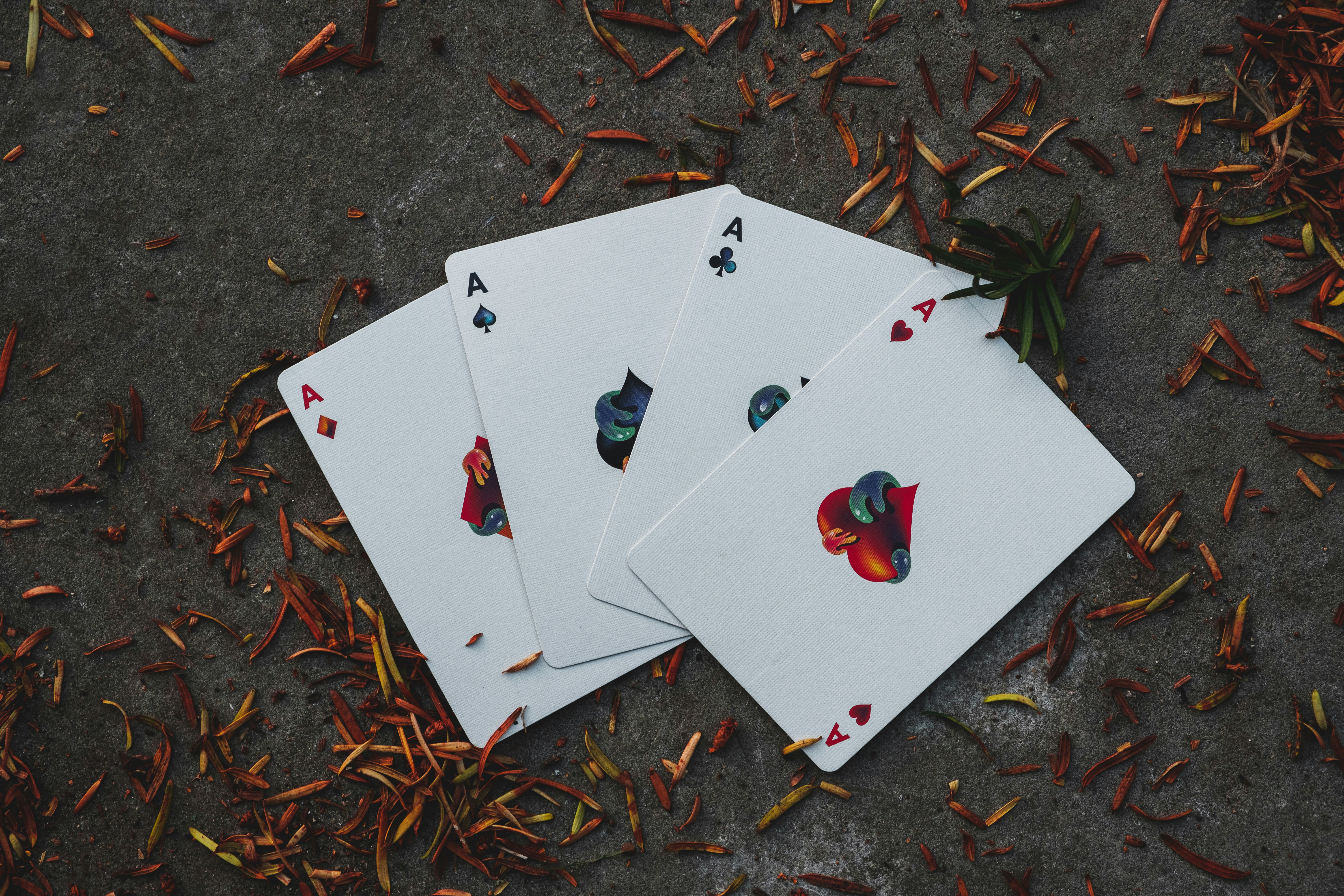 3 of hearts playing card on brown dried leaves
