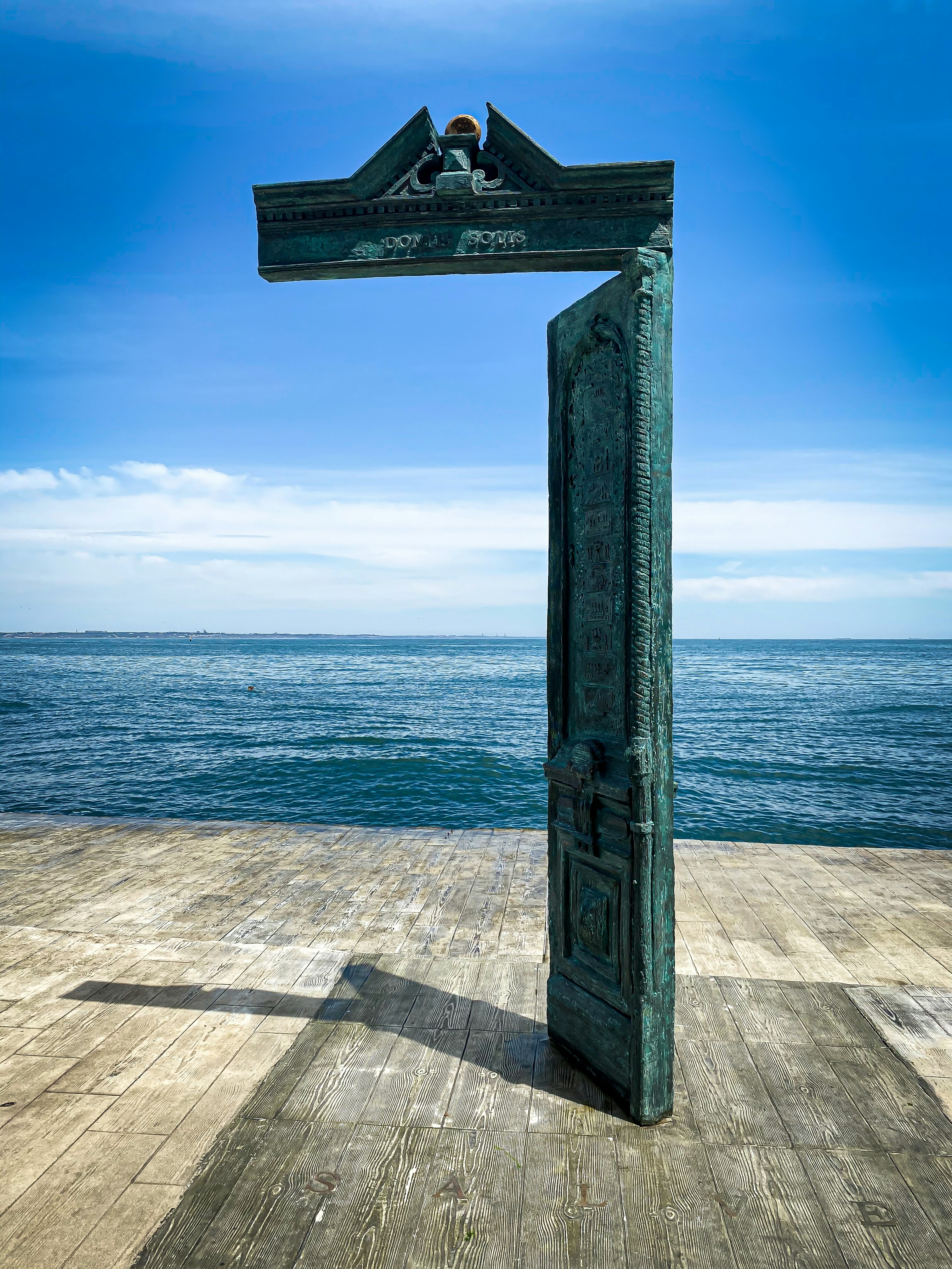 Teal Gate by the Sea: A Weathered Portal on the Pier