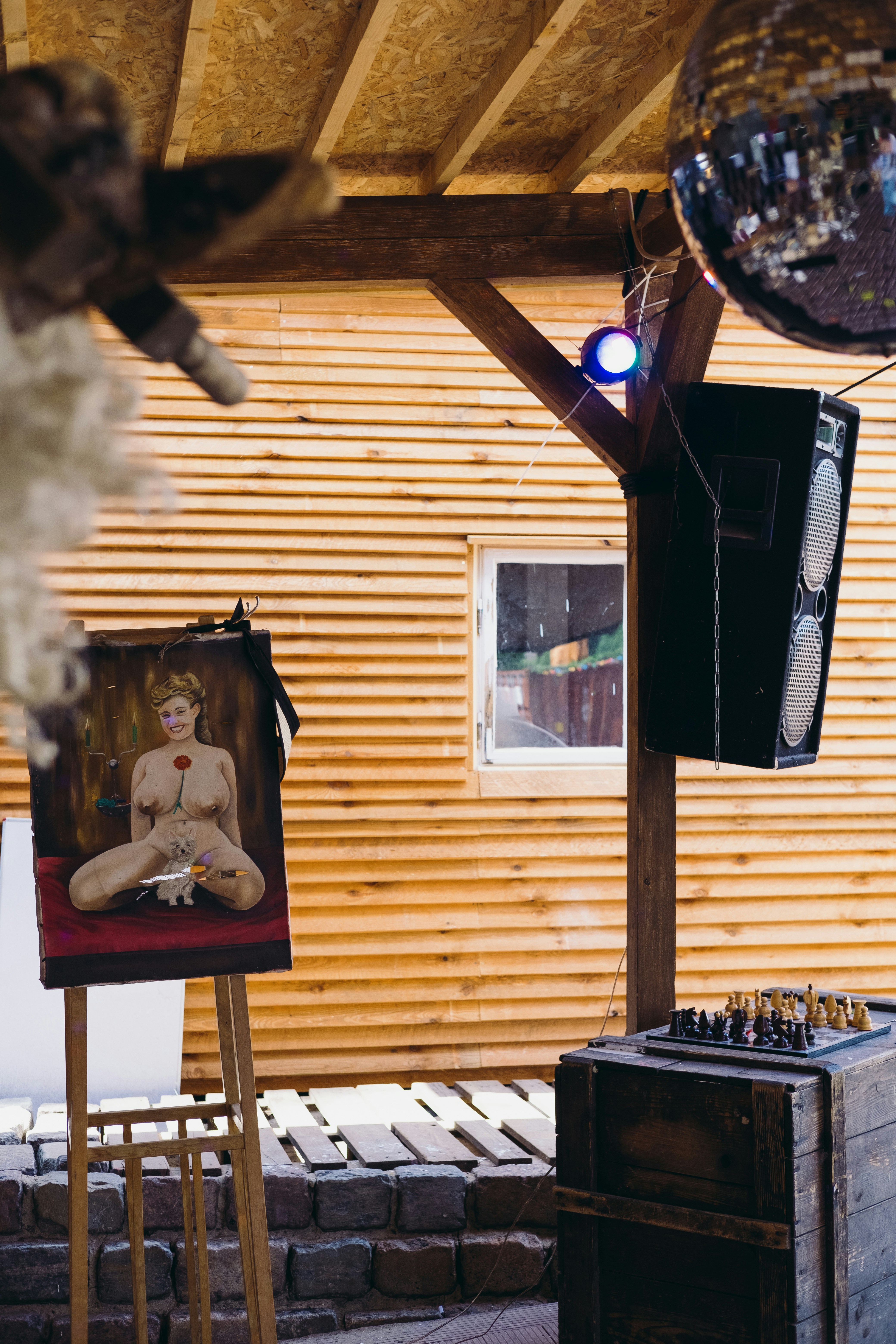 Nude Portrait on an Easel Amid Rustic Studio Lights and a Disco Ball