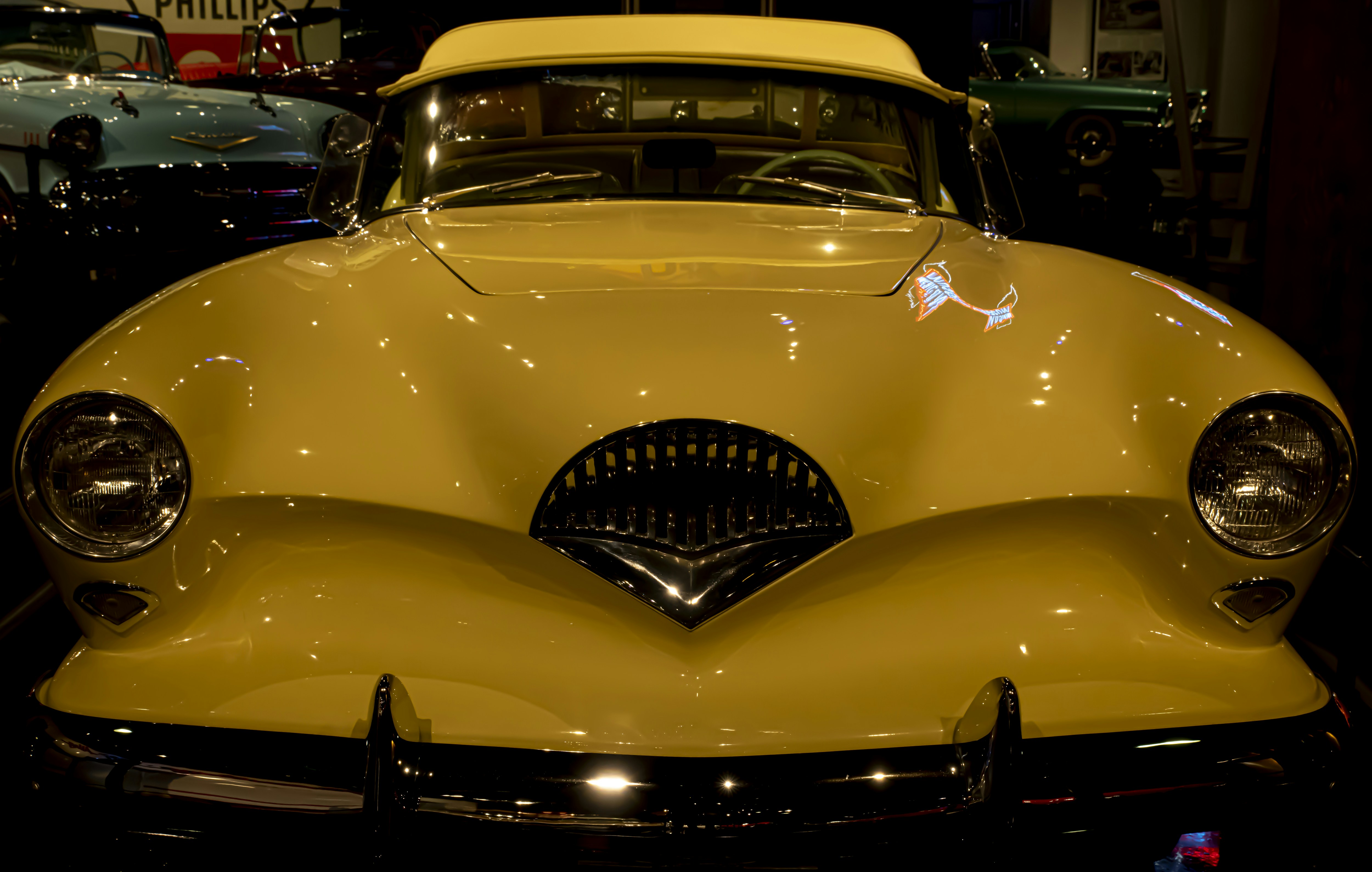 Sunlit Classic Hood: A 1950s Yellow Beauty in an Indoor Showroom