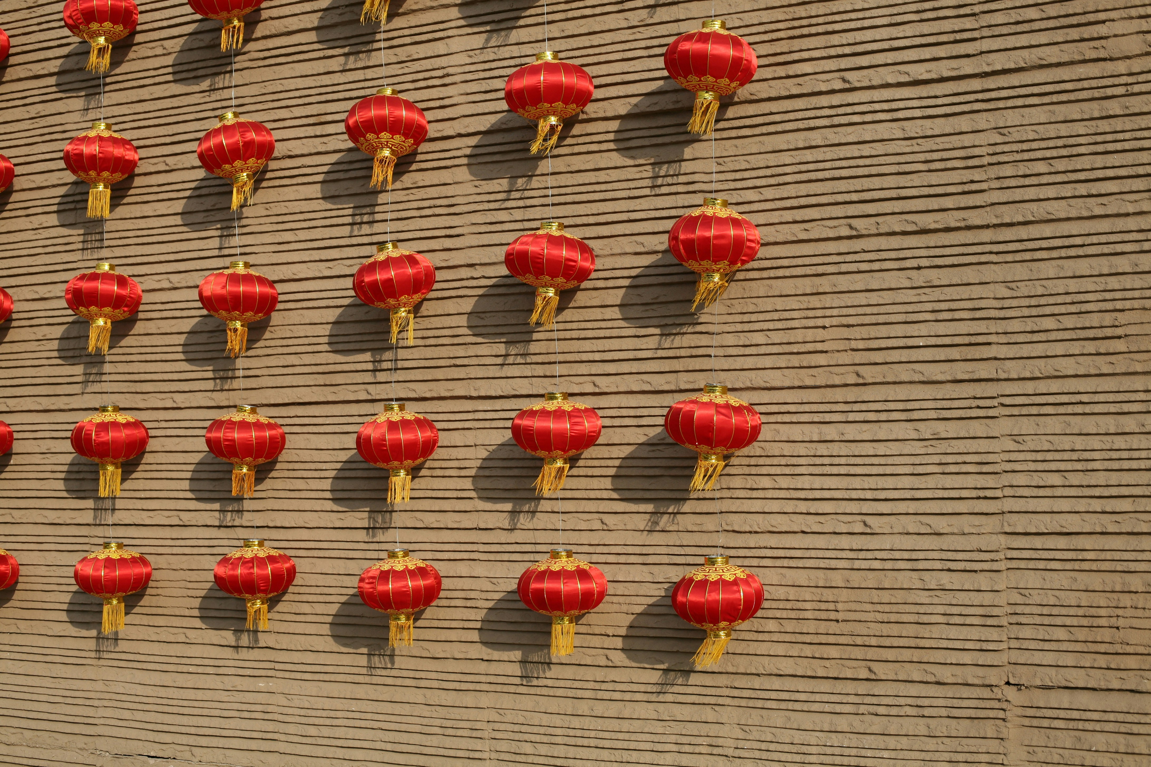 Crimson Lantern Grid on a Textured Brick Wall