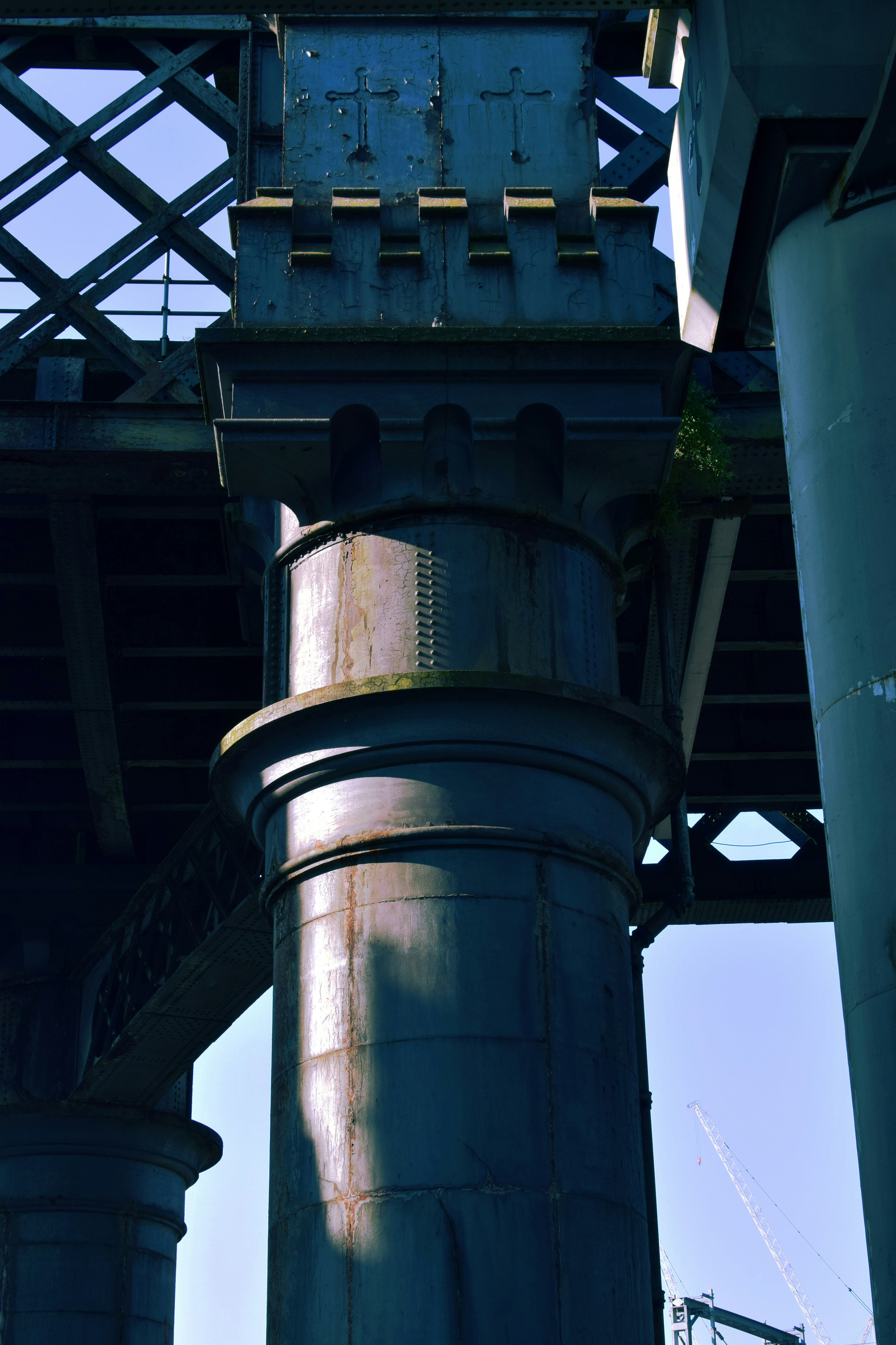 Azure Pillar Beneath the Span: A Close-Up of Weathered Steel
