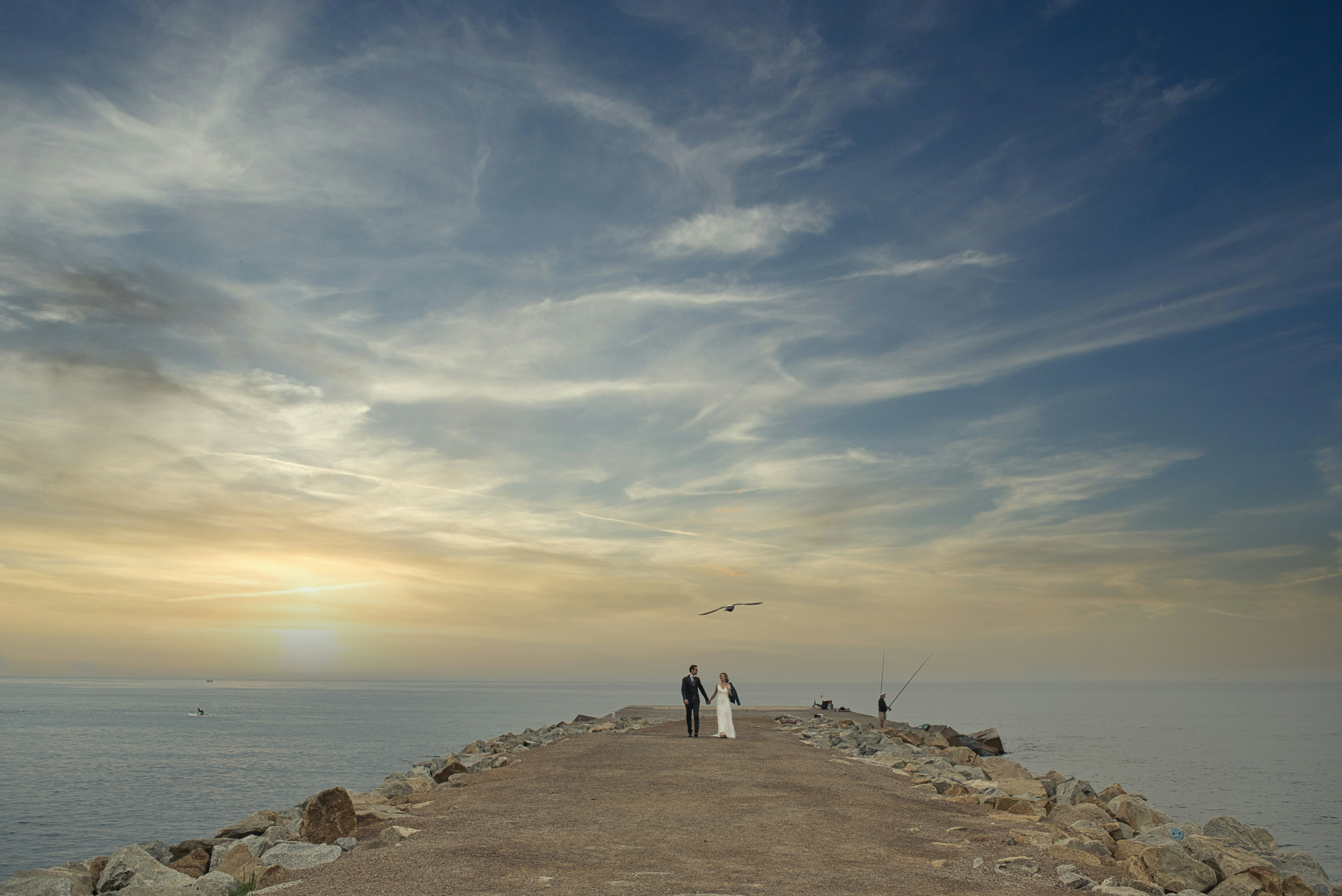 Two Walkers at Sunset on a Seaward Breakwater
