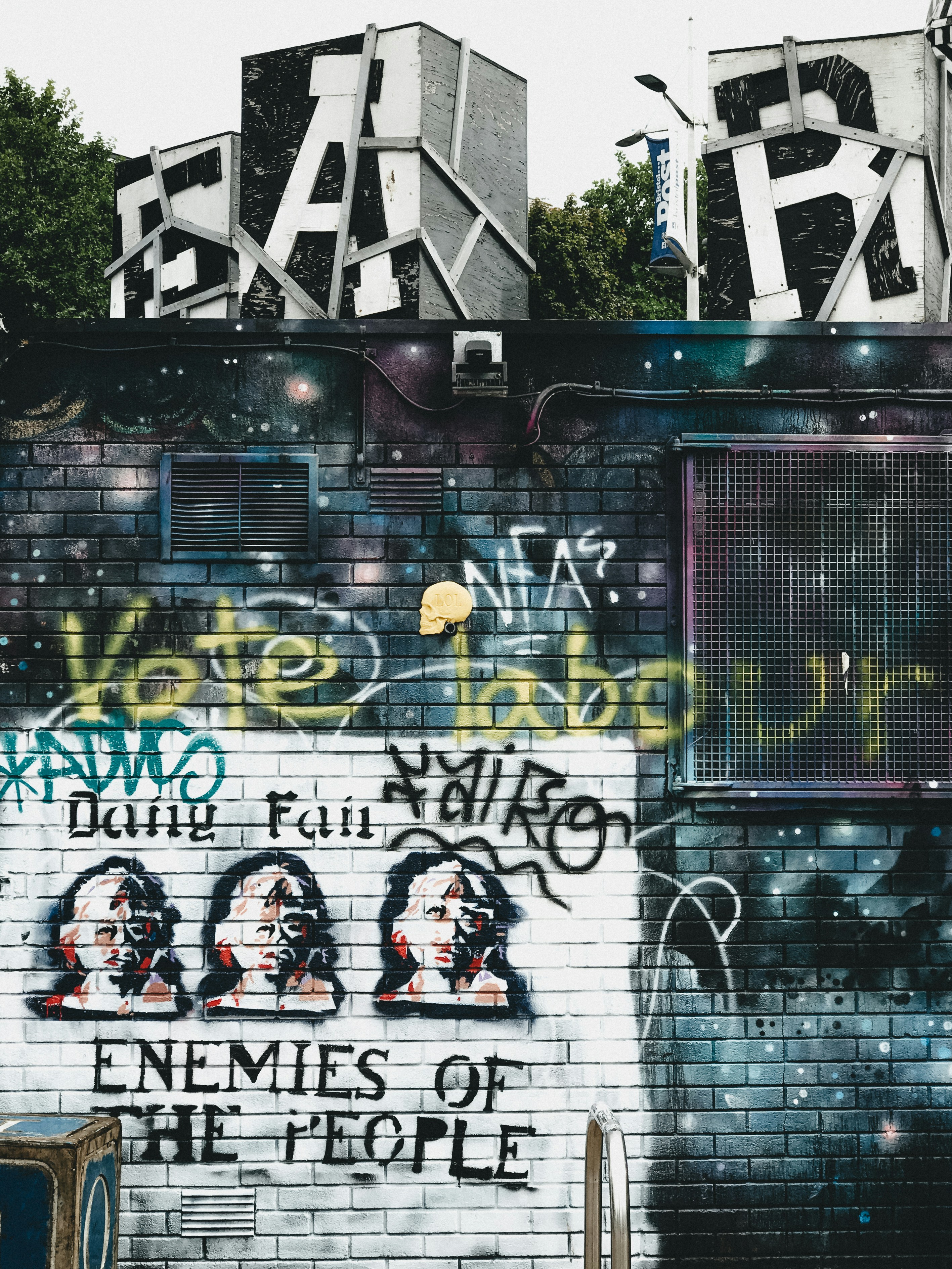 Graffiti Portraits and Urban Graffito: Enemies of the People on a Weathered Brick Wall