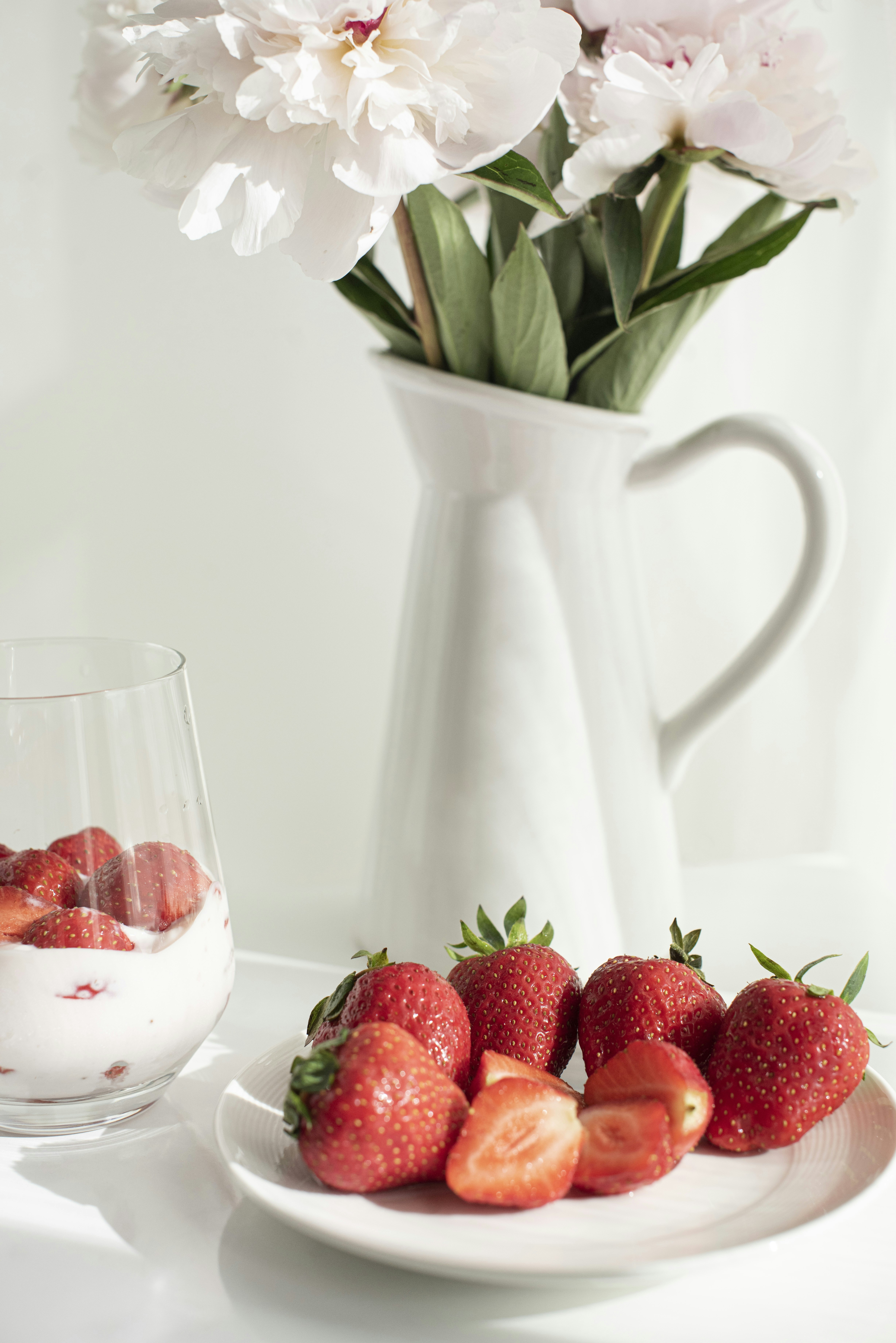 Luminous Simplicity: Strawberries, White Pitcher, and Soft Peonies in Studio Light