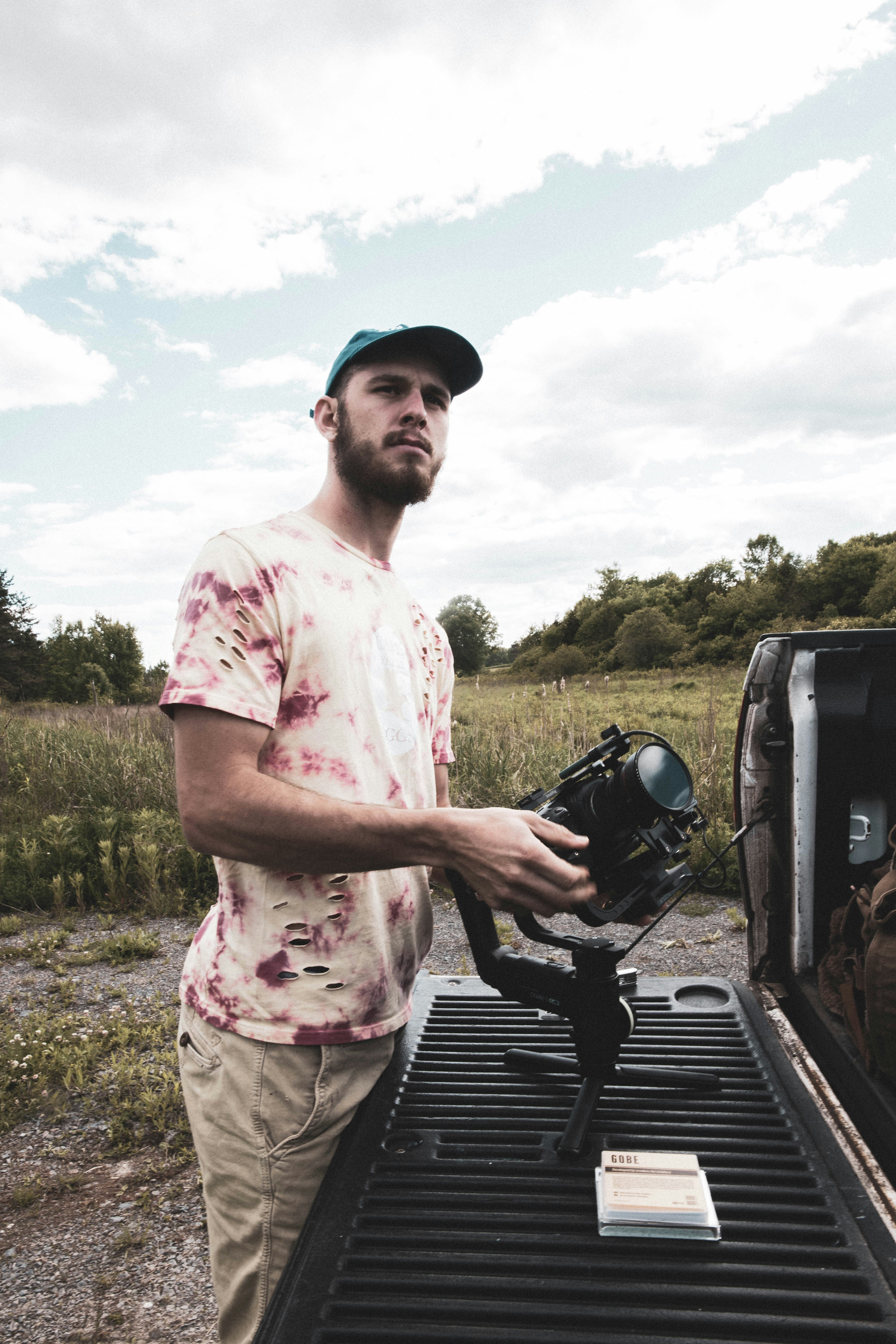 Field Ready: A Cameraman with a Gimbal Beside an Open Truck