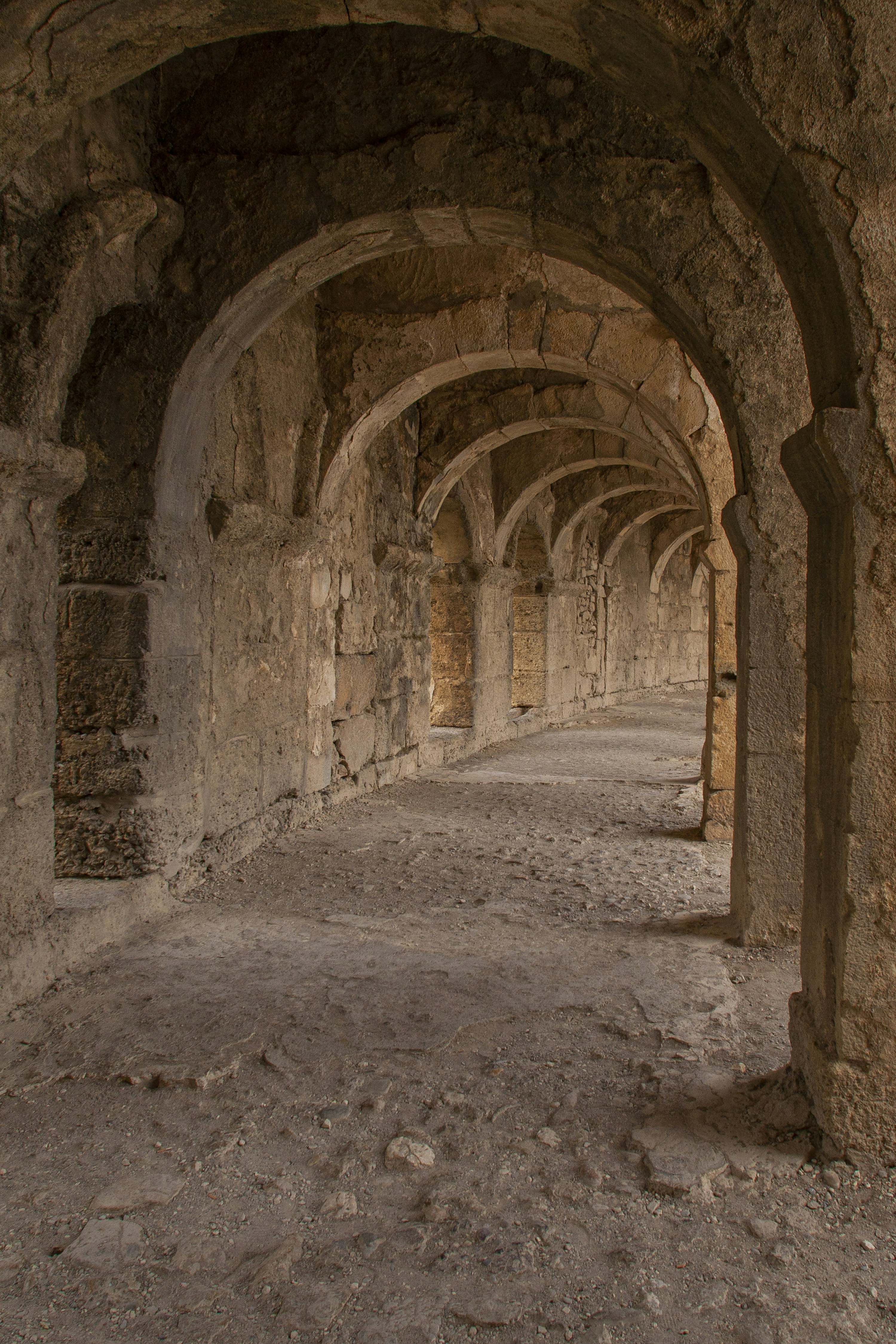 The theater arches in Aspendos Theater, a marvelously well-preserved Roman Theater in southern Turkey. | gray concrete tunnel during daytime