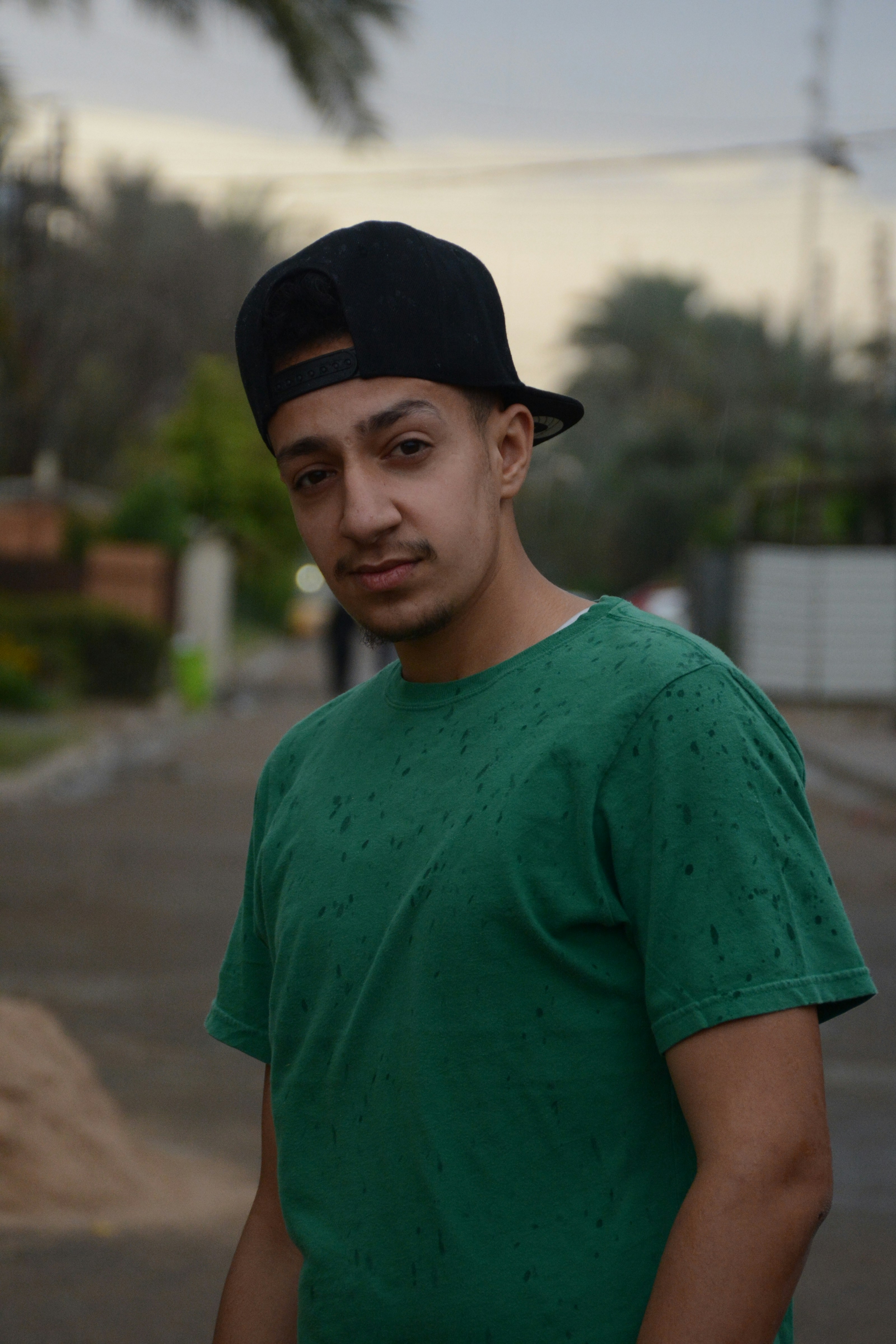 a man in a green shirt and a black hat