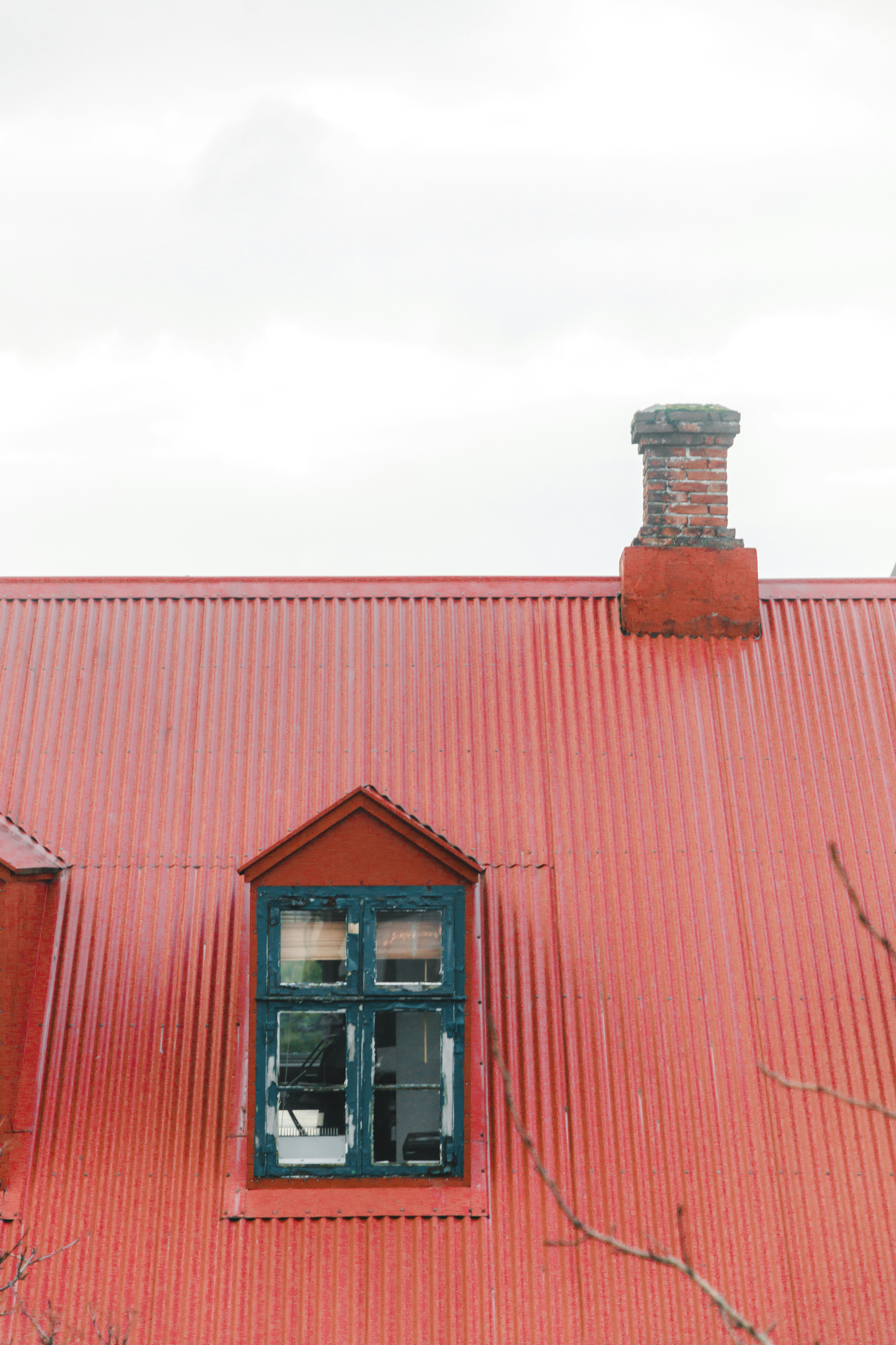 Crimson Roof, Teal Window: Quiet Geometry Under an Overcast Sky