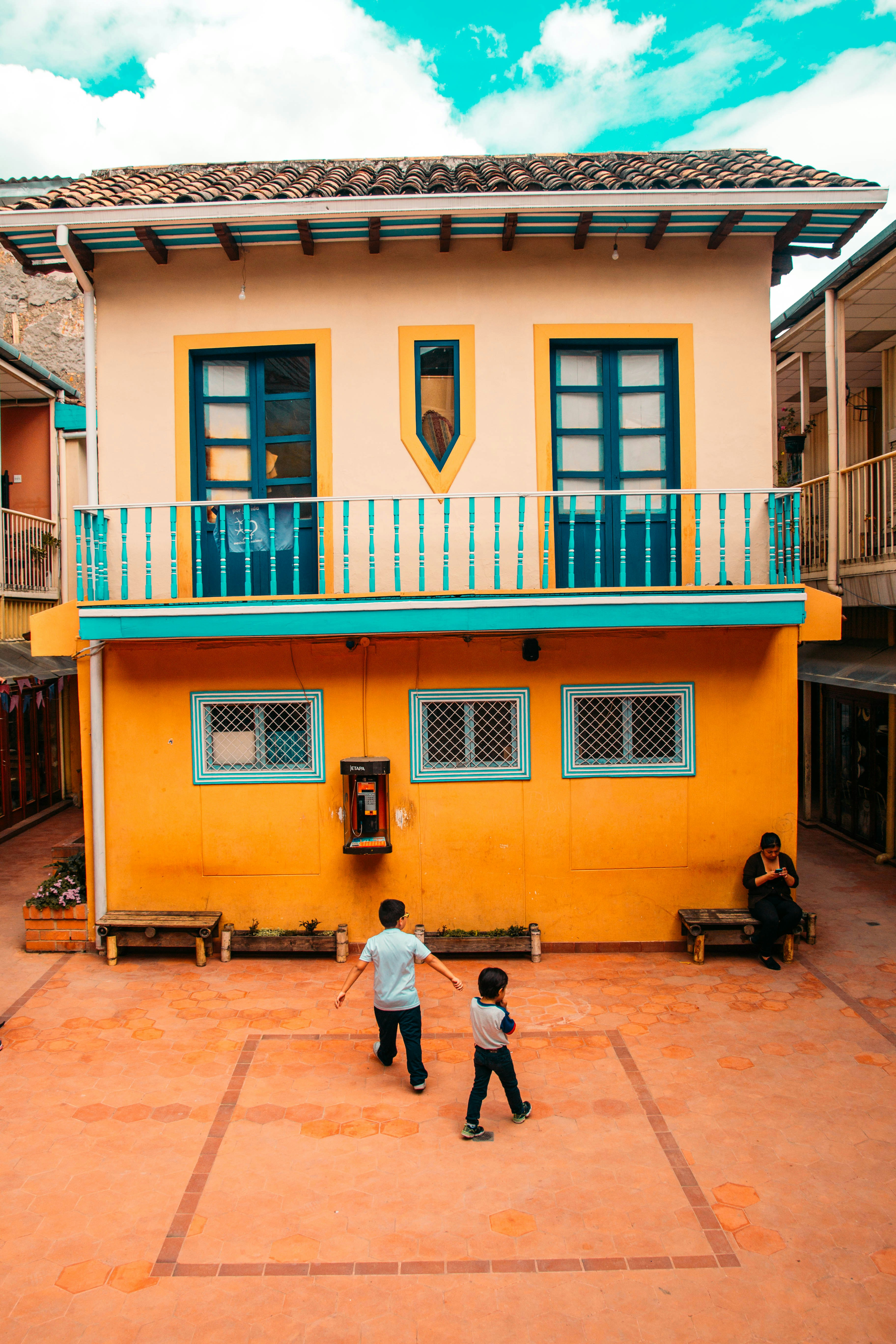 Playful Dash in a Citrine Courtyard Framed by a Teal Balcony