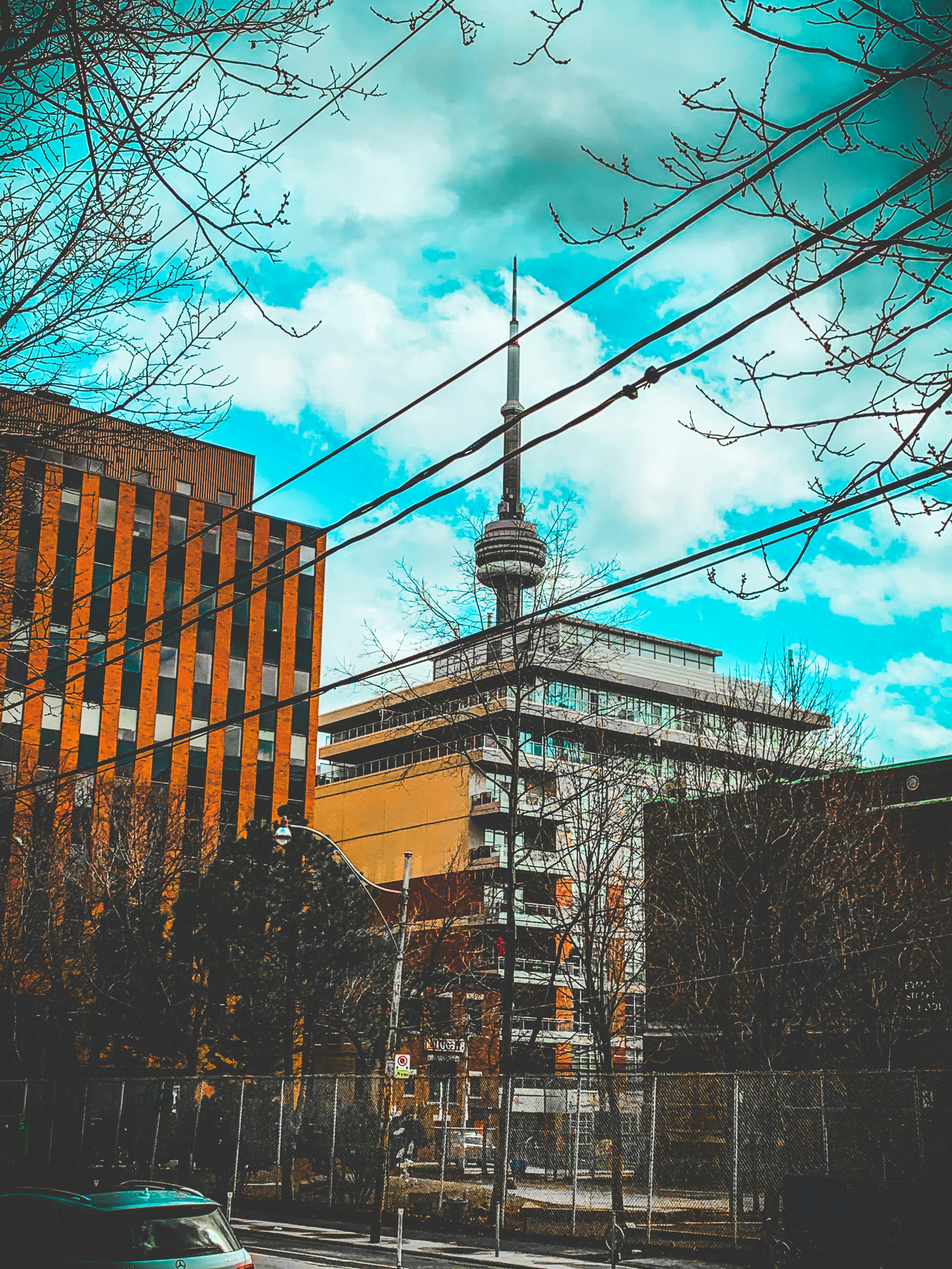 Urban Geometry: Tower Framed by Crossing Cables Under a Cyan Sky
