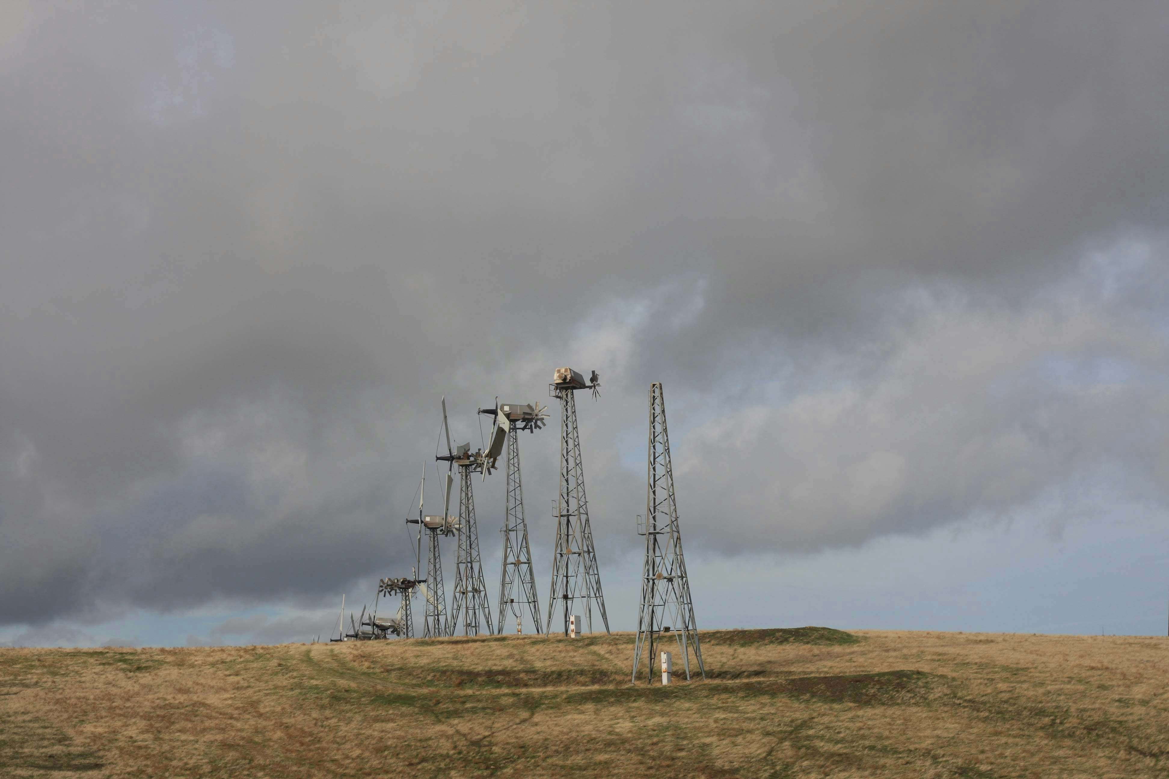 White wind turbines on brown field under gray cloudy sky photo – Free ...