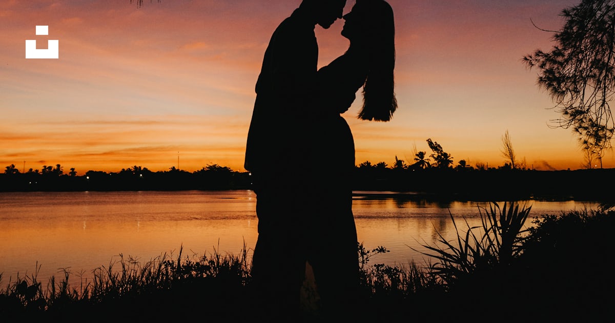 Silueta De Hombre Y Mujer Besándose Durante La Puesta Del Sol Foto