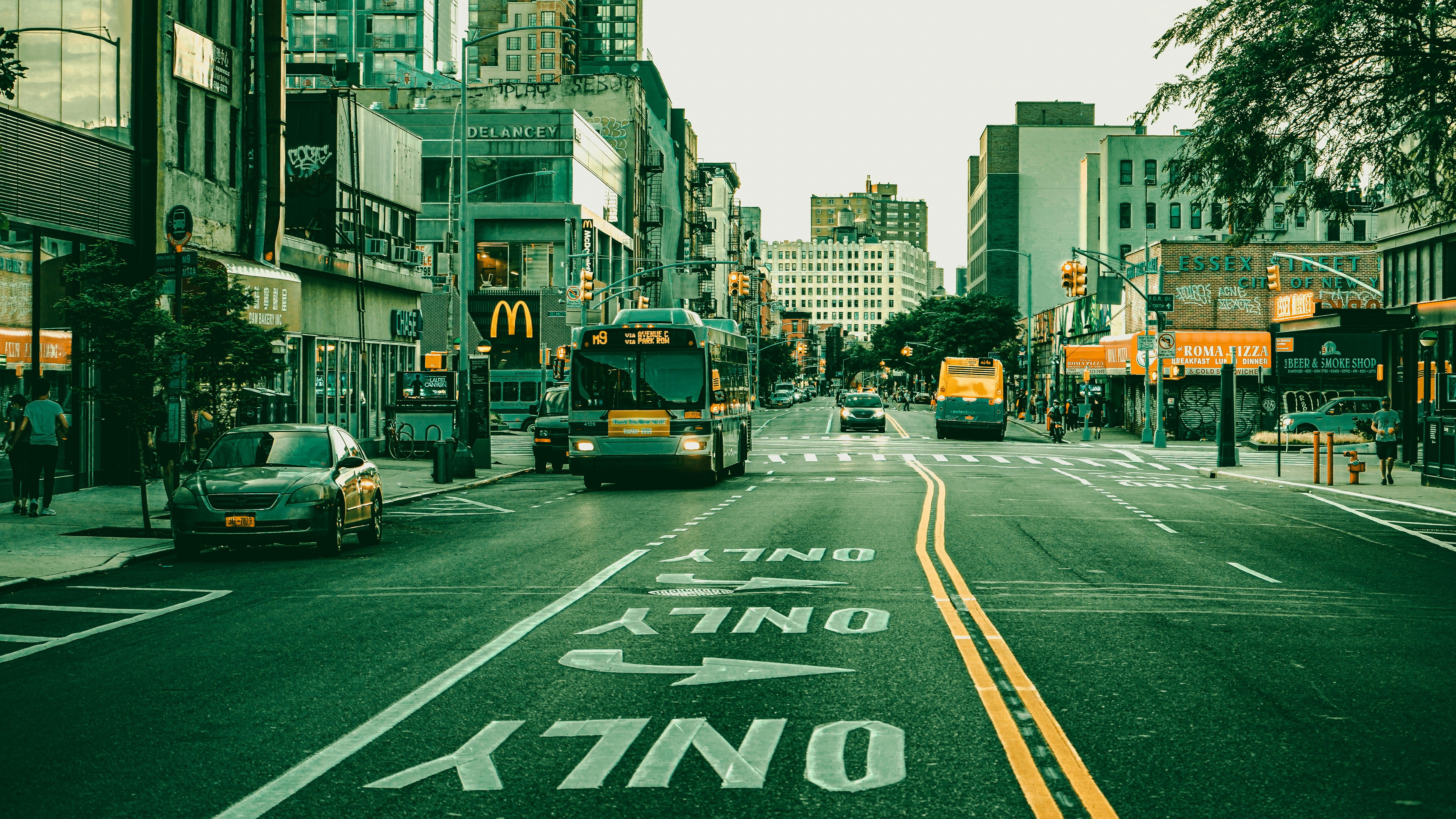 Verdant Horizon: A bus-filled downtown street converging toward a distant intersection