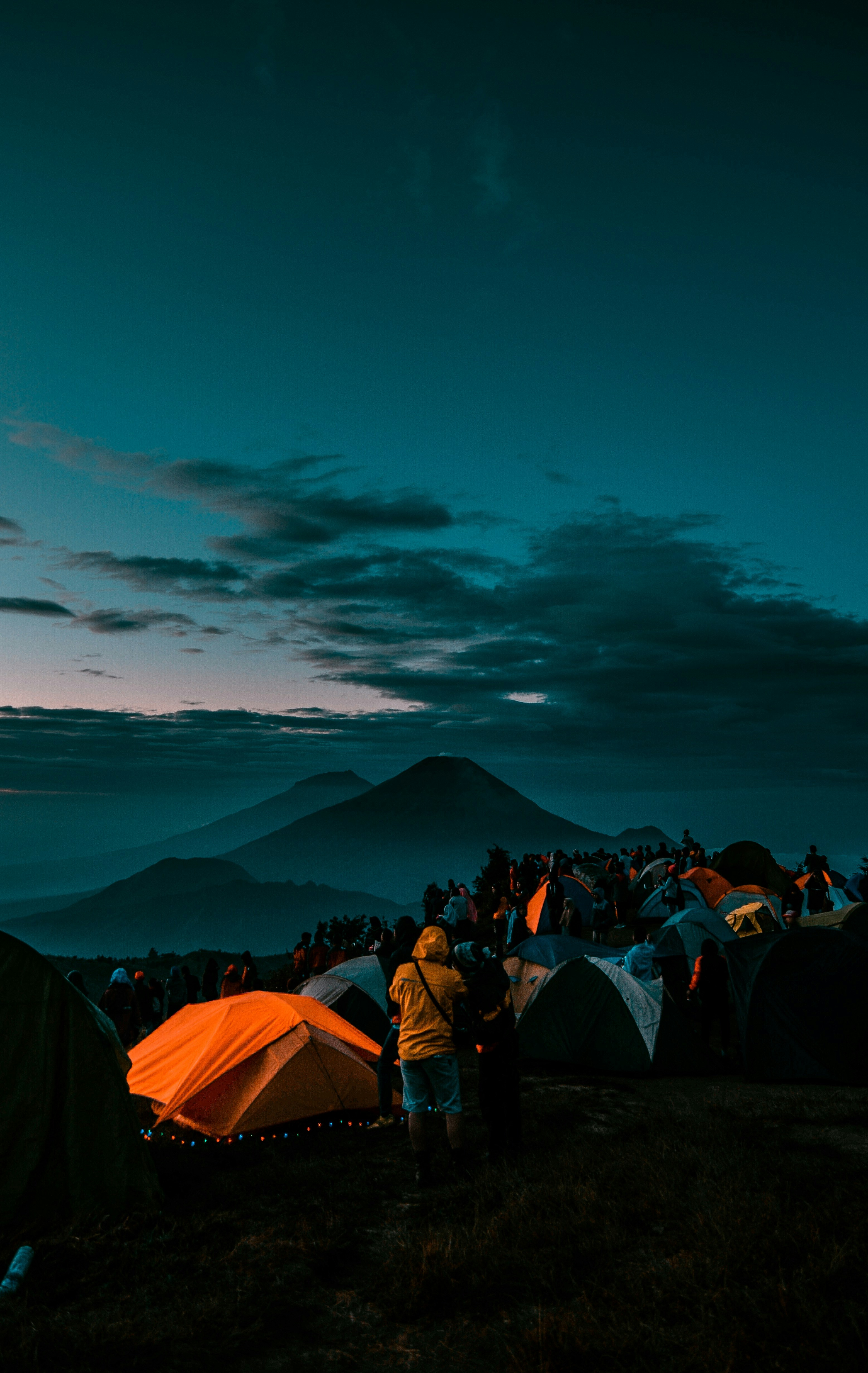 Group of people sitting on camping chairs near mountain during night ...
