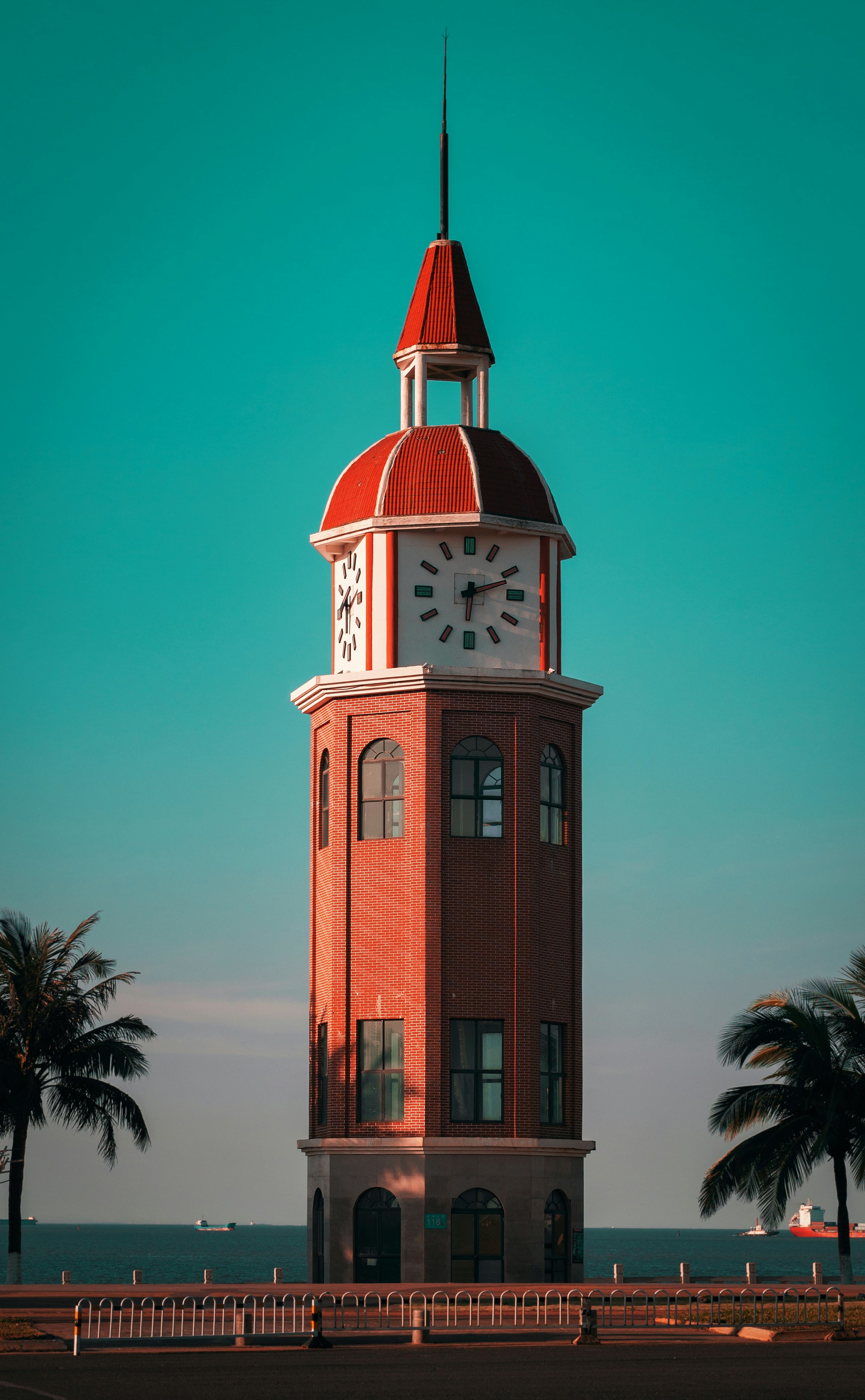 Clocktower by the Sea: A Red Brick Beacon under a Teal Sky