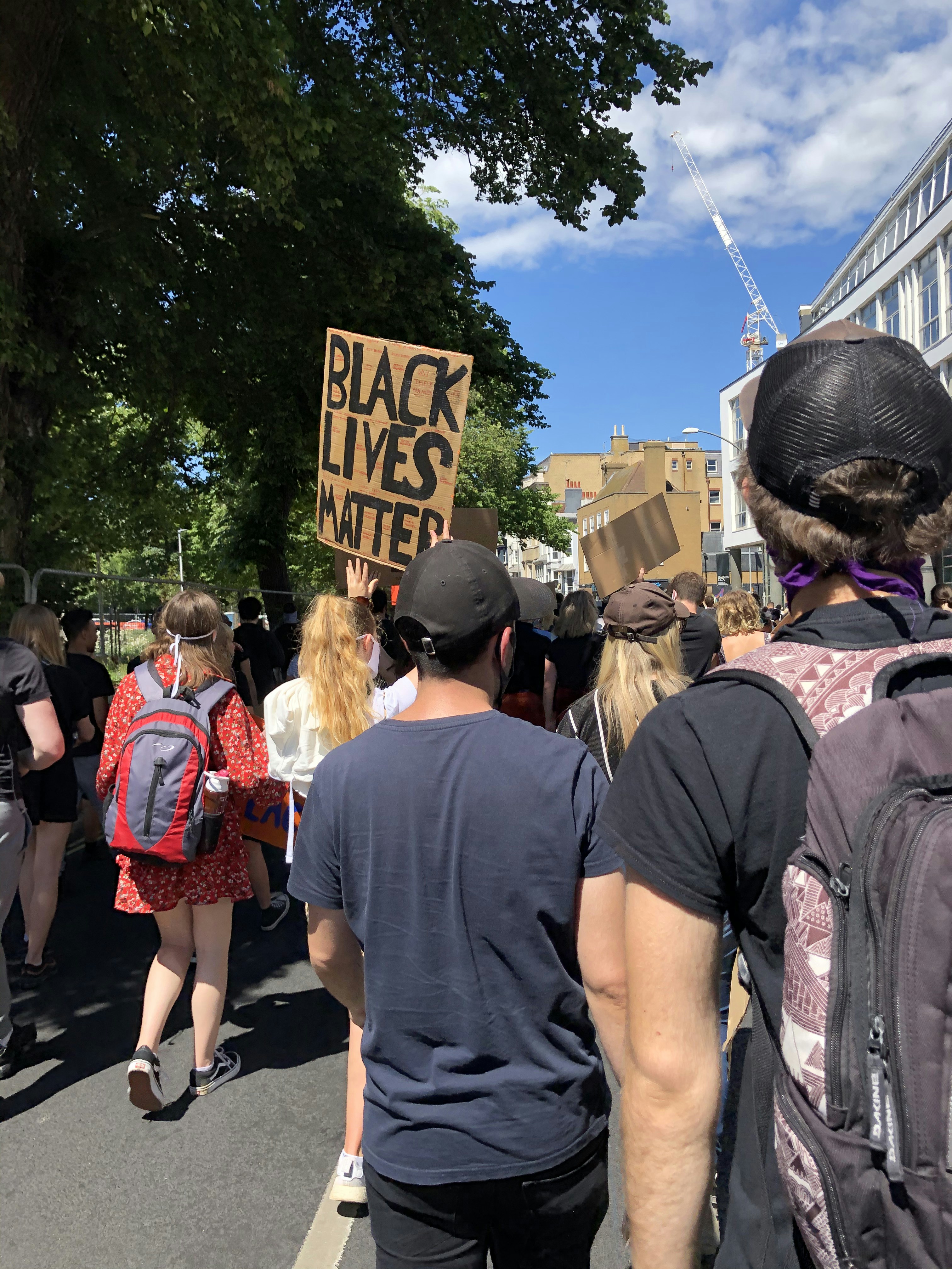 Participants march together, holding signs advocating for racial equality during a public demonstration.