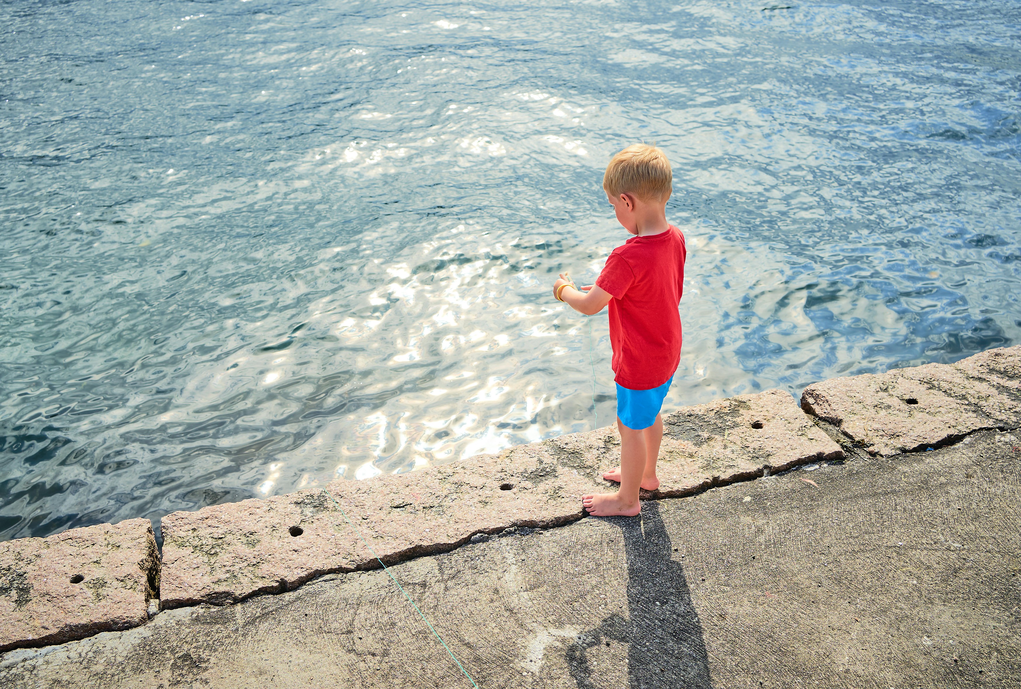 Edge of Light: A Boy in Red on the Stone Ledge