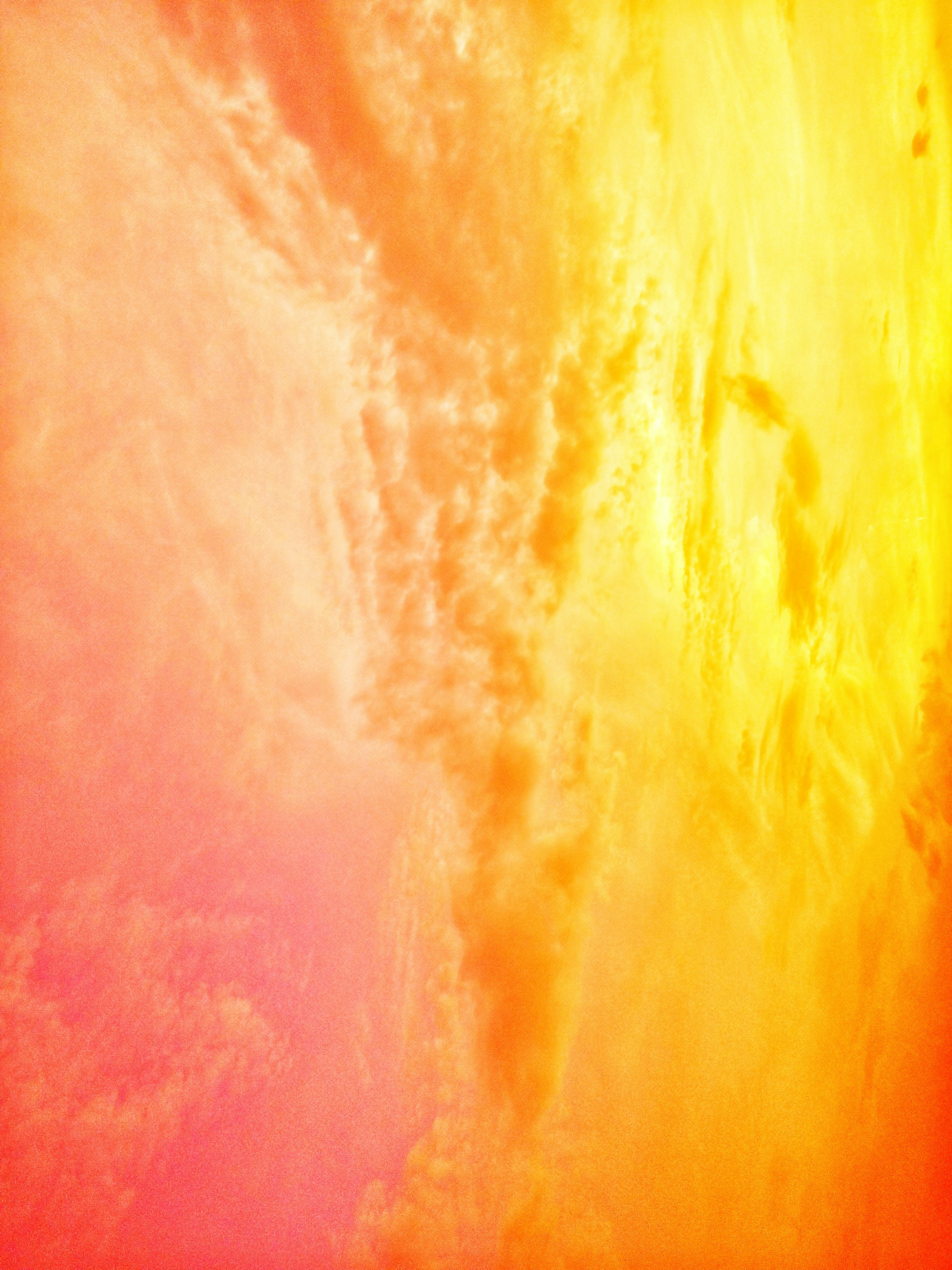 Vibrant clouds illuminated by a warm, golden hue, blending shades of pink and orange in the sky.