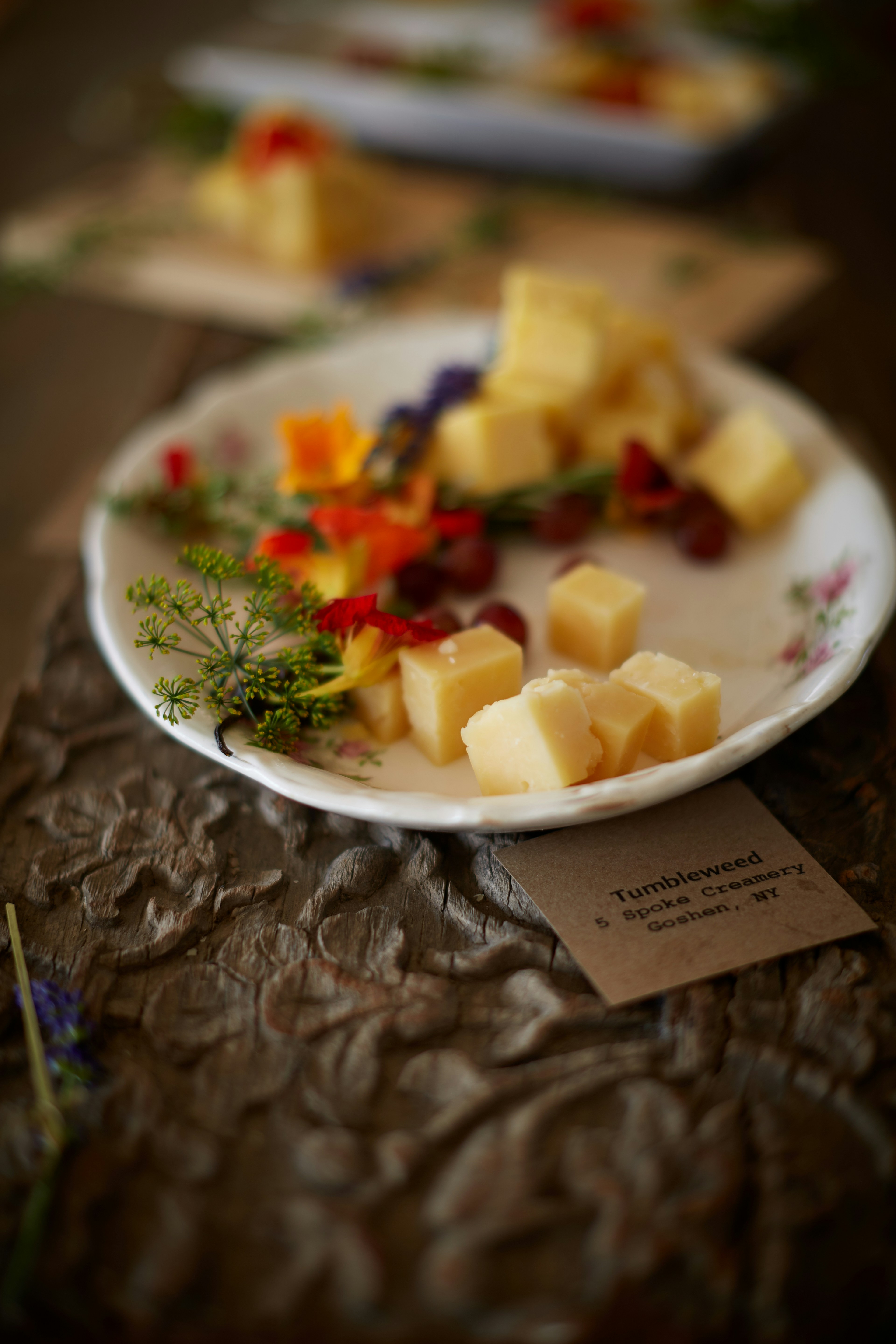 Cheese Mosaic: Cubes, Herbs, and Soft Light on a Rustic Board