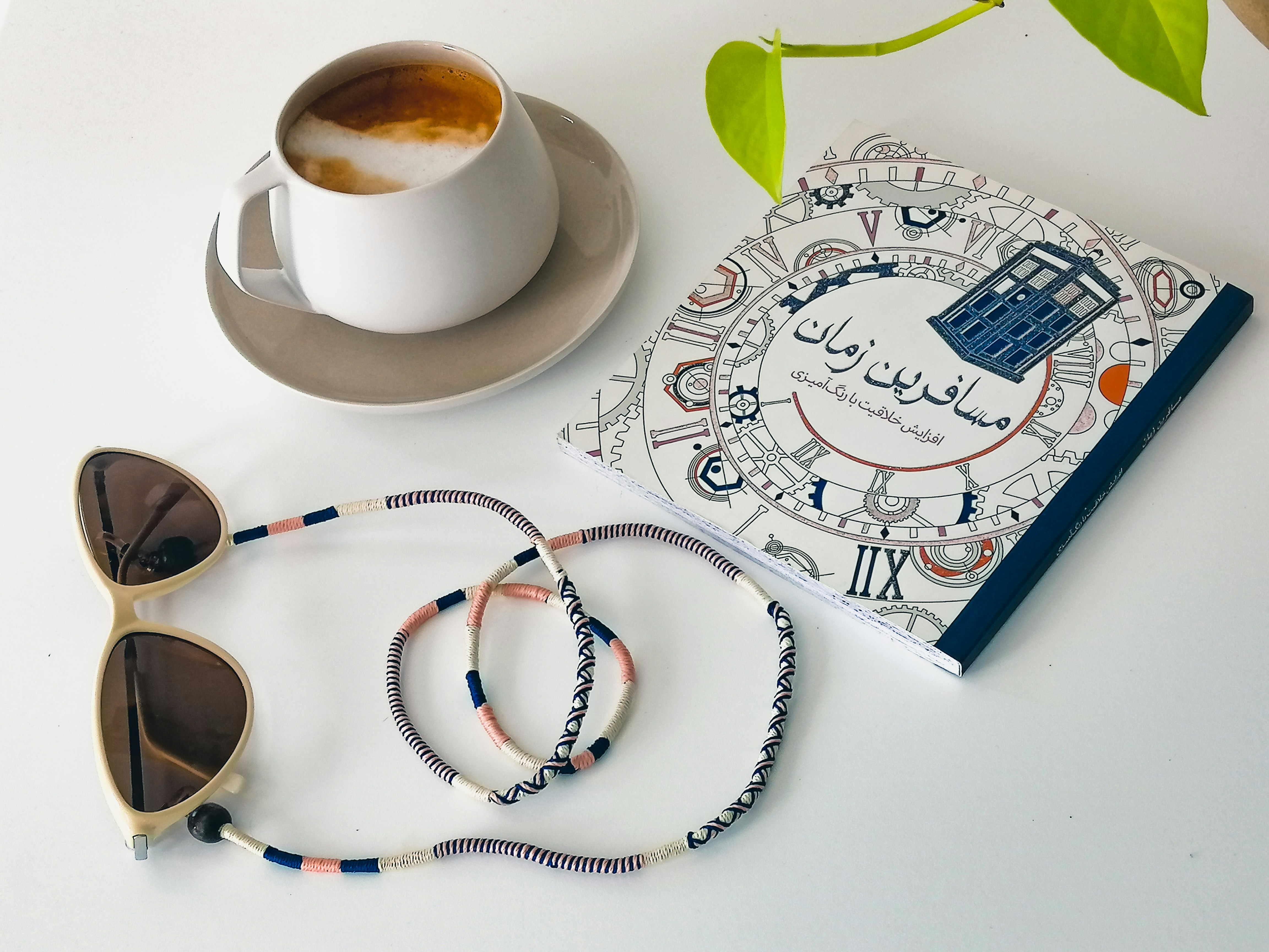 Morning Minimalism: A White Cup, Braided Bracelets, and a Travel Notebook on a Clean Desk